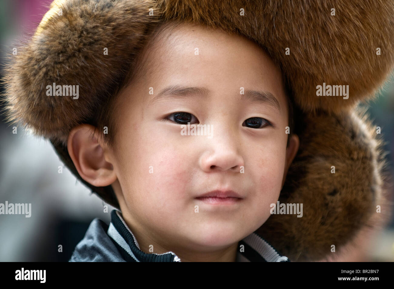 Ethnic Tibetan young boy wearing fur cap attend folk dance and music ...
