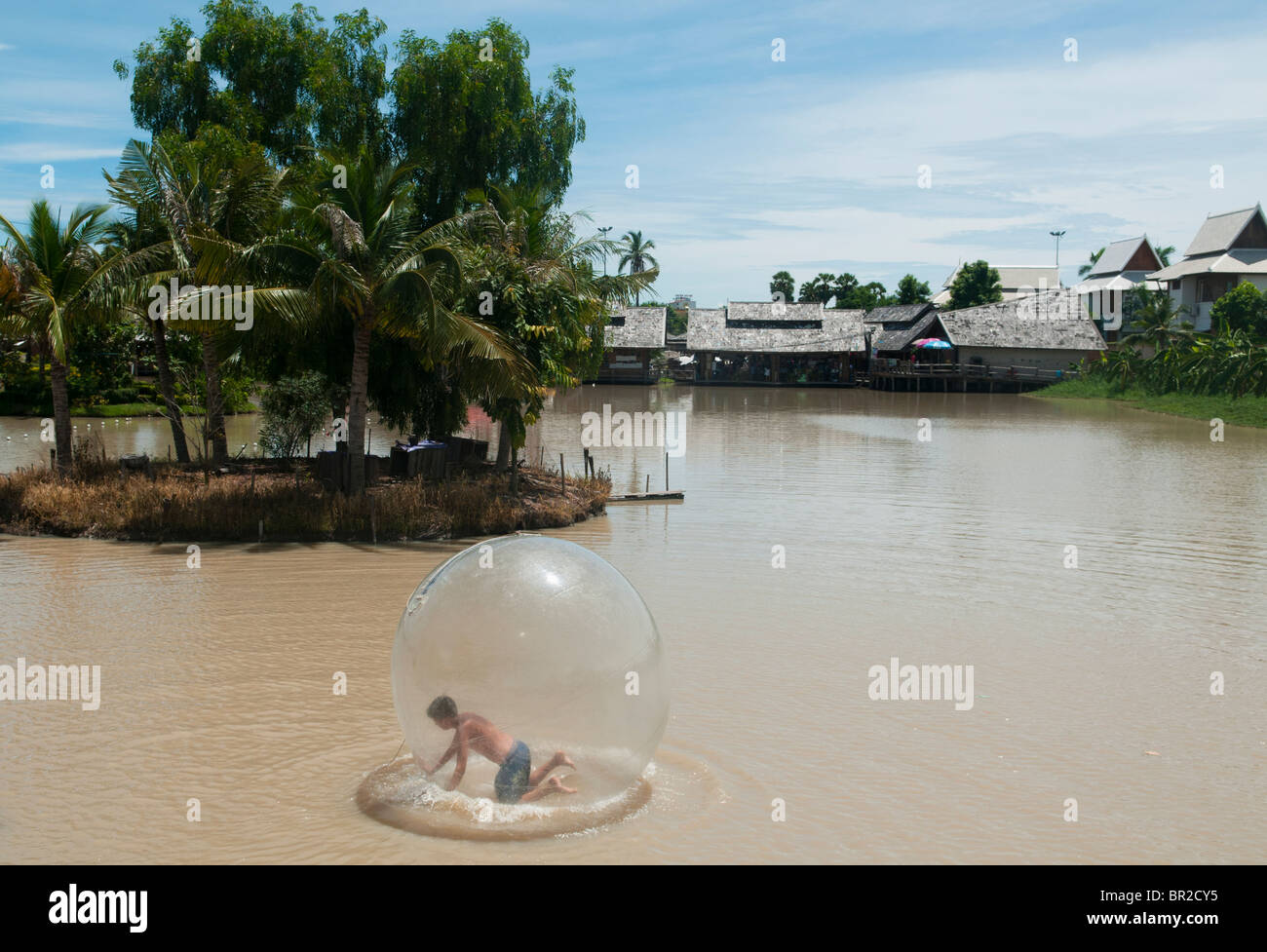 boy in a plastic bubble at the floating market in Pattaya, Thailand ...