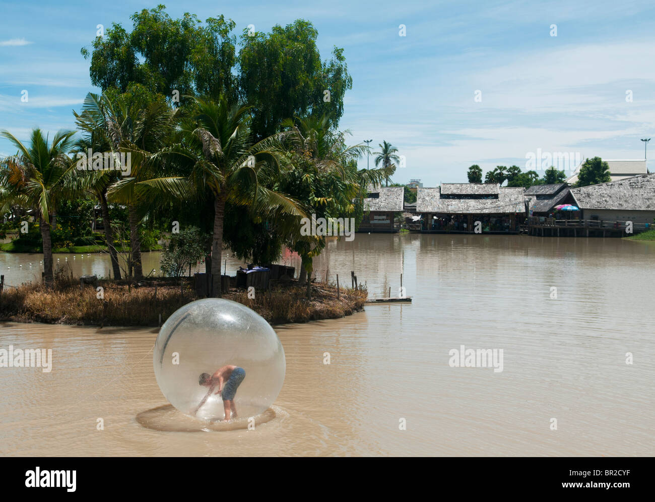 boy in a plastic bubble at the floating market in Pattaya, Thailand ...