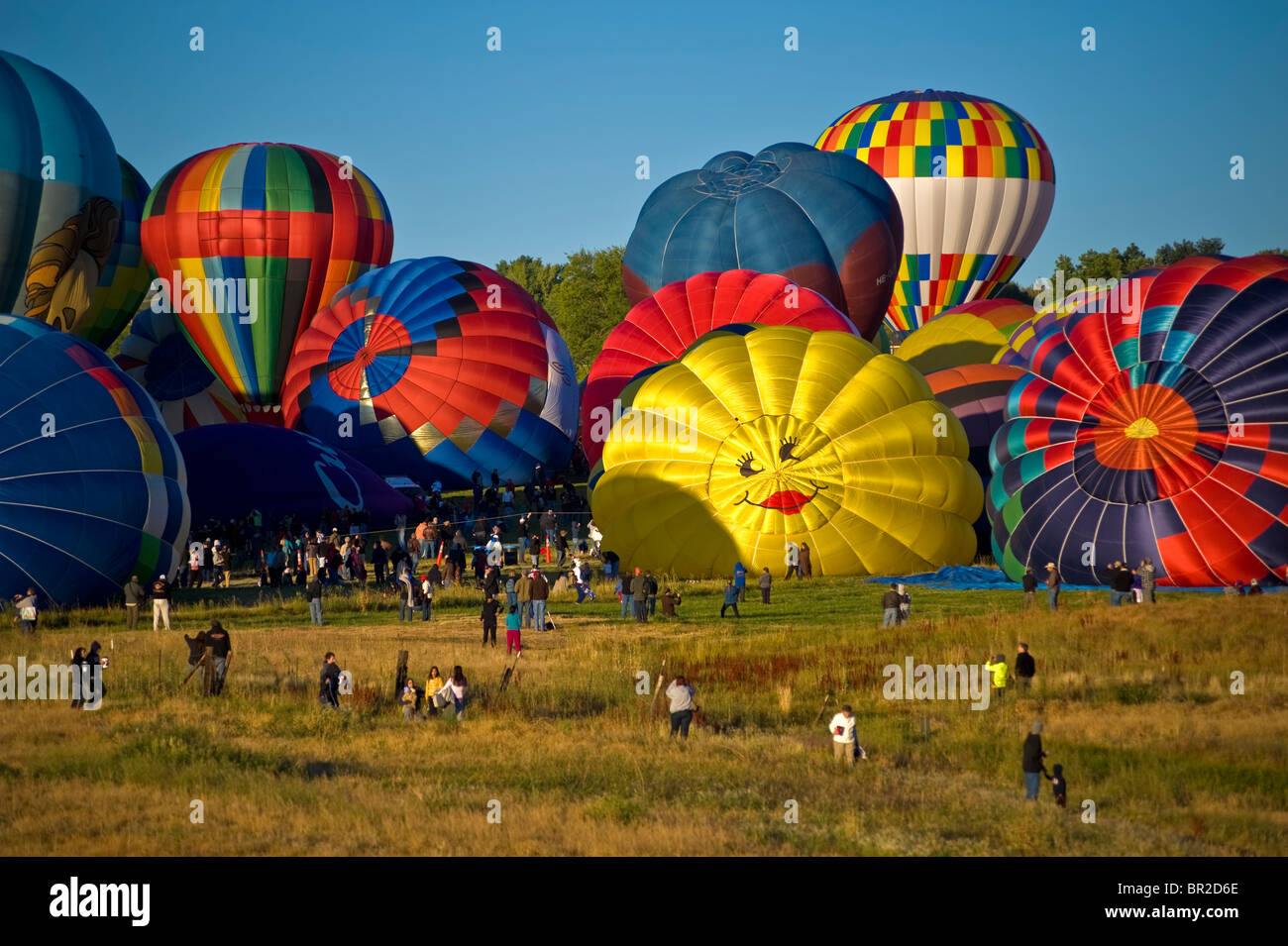 Early inflation of many hot air balloons while crowd watches at the ...