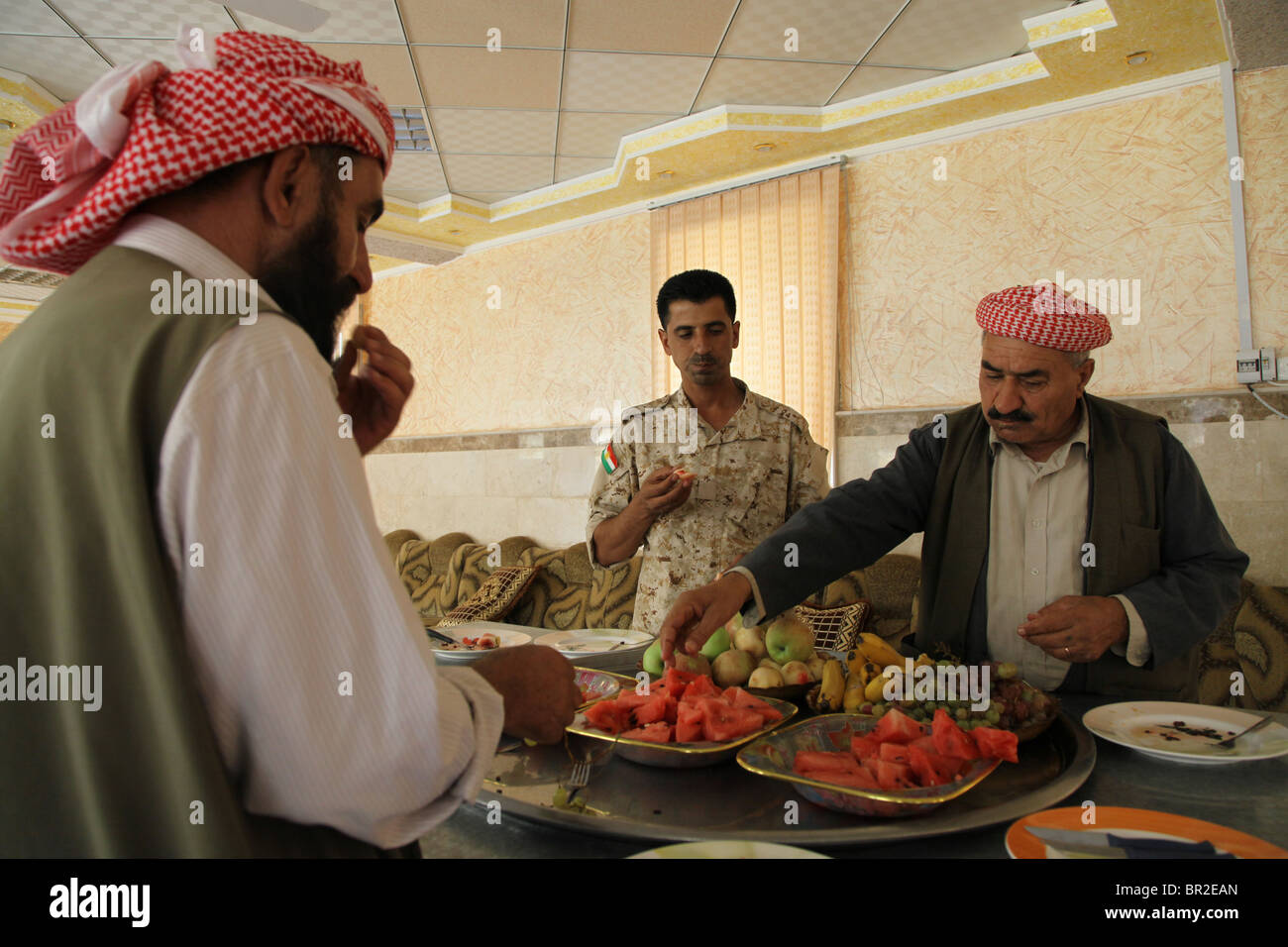 Yazidi men eating traditional Kurdish food in the village of Lalish ...