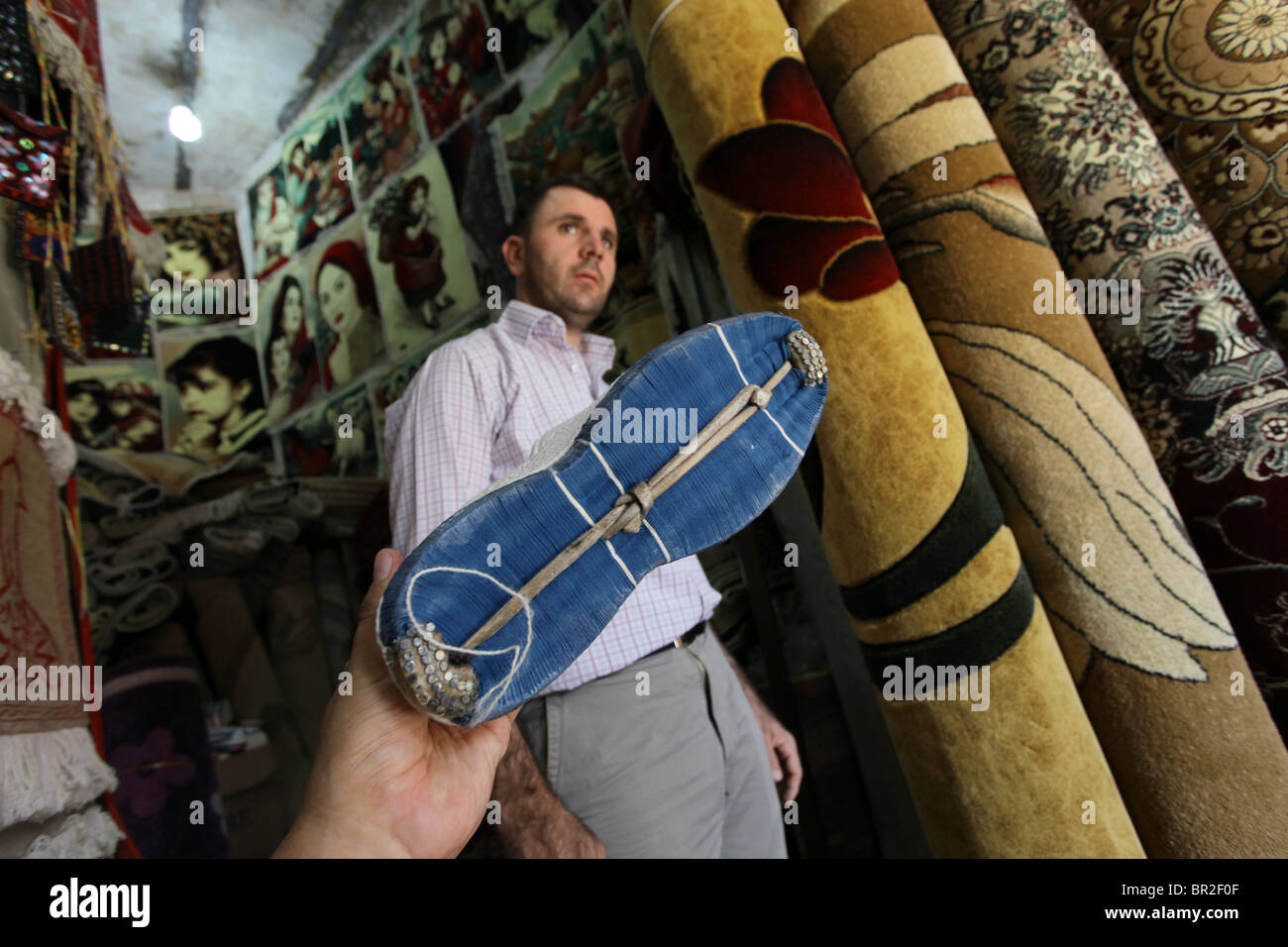 Man holds a traditional 'Klash' hand made cotton wool shoe made in ...