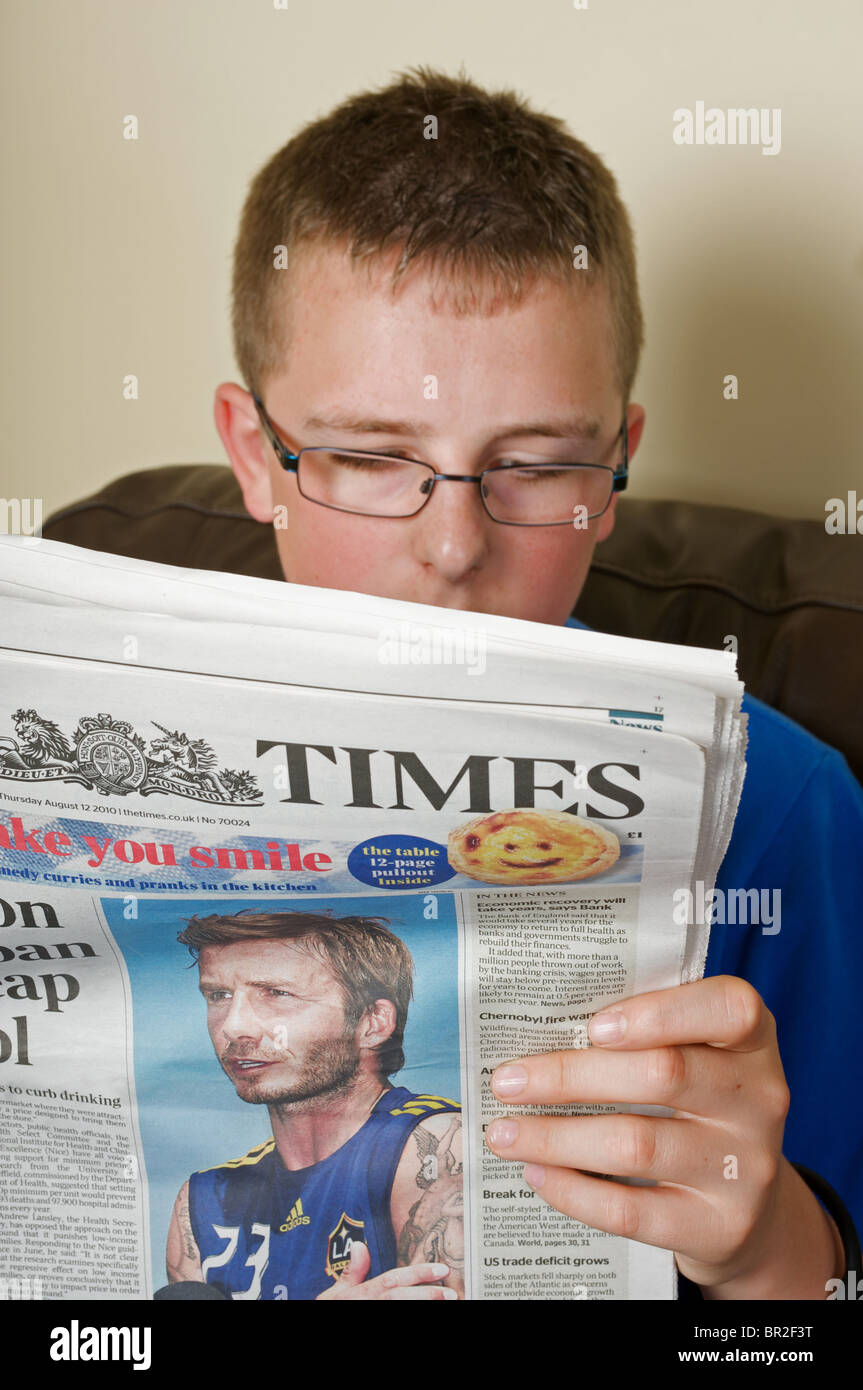 Teenage boy reading The Times newspaper Stock Photo - Alamy