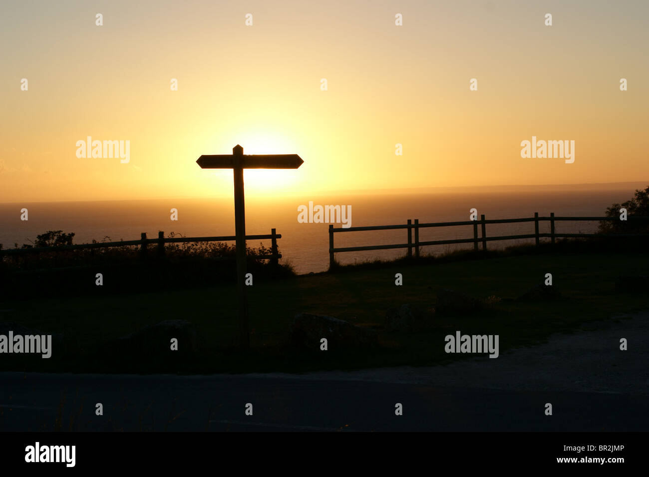 Signpost silhouetted against the sunset Stock Photo - Alamy