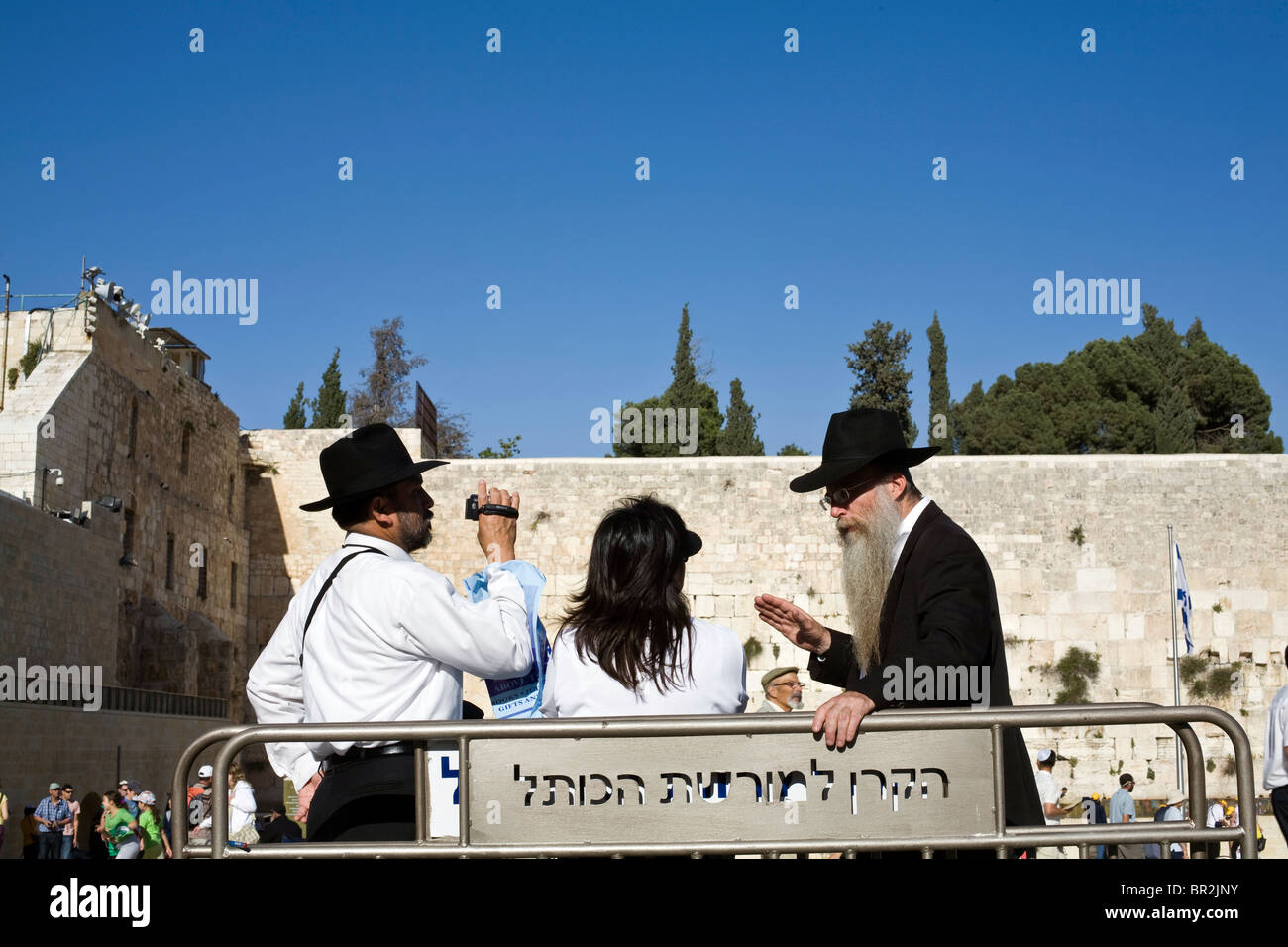 A woman talks to two Orthodox Jewish rabbis at the Western ('Wailing ...