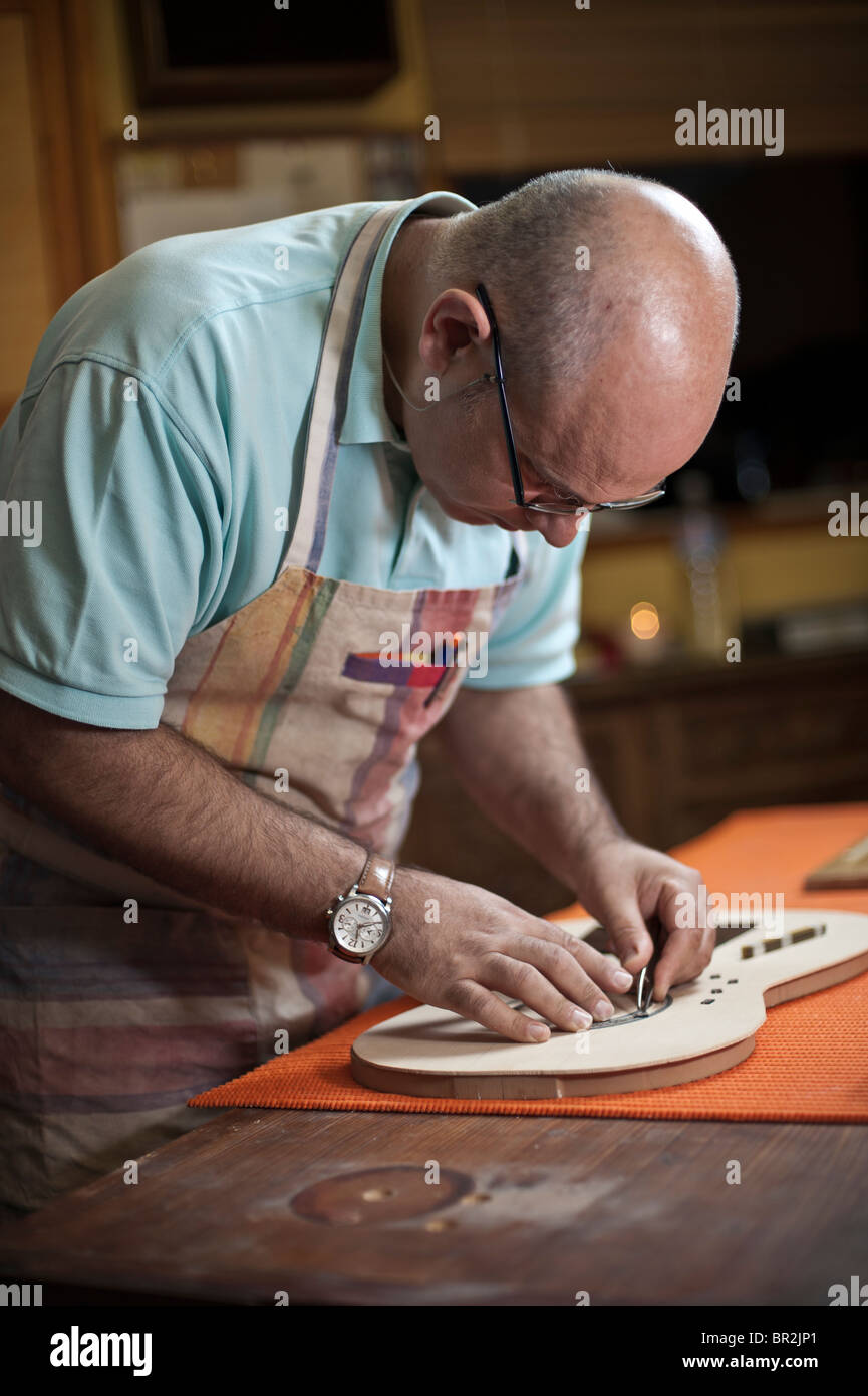 Master Luthier (Guitar-Maker) in his workshop in the process of making ...