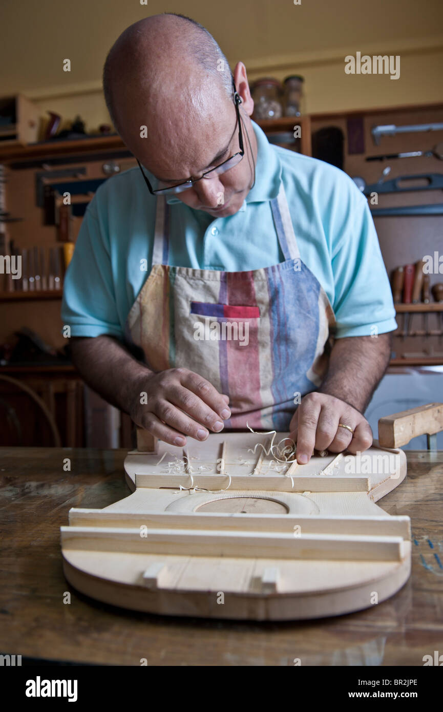 Master Luthier (Guitar-Maker) in his workshop in the process of making ...
