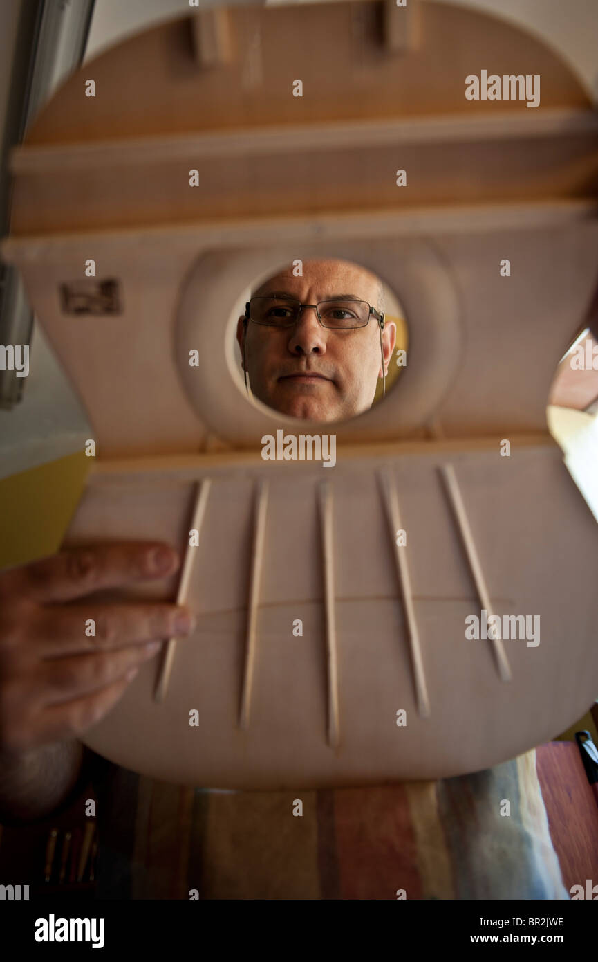 Master Luthier (Guitar-Maker) in his workshop in the process of making ...