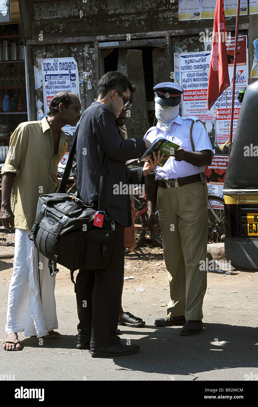Middle eastern tourist with baggage taking directions from a guidebook ...