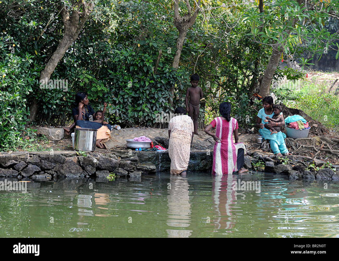 Indian family at waters edge, the backwaters of Kerala, India Stock ...