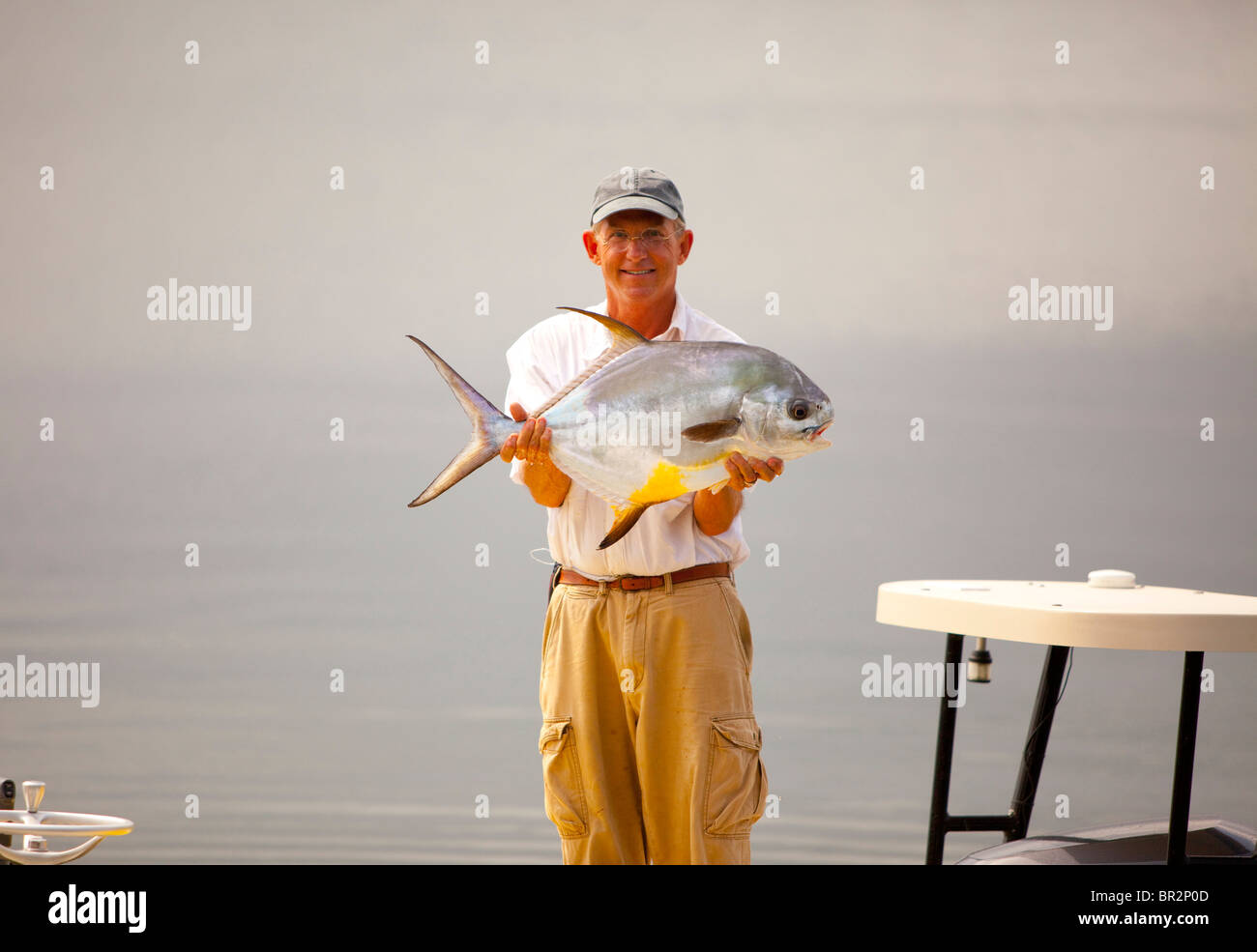 Portrait of fisherman holding a caught fish Stock Photo - Alamy
