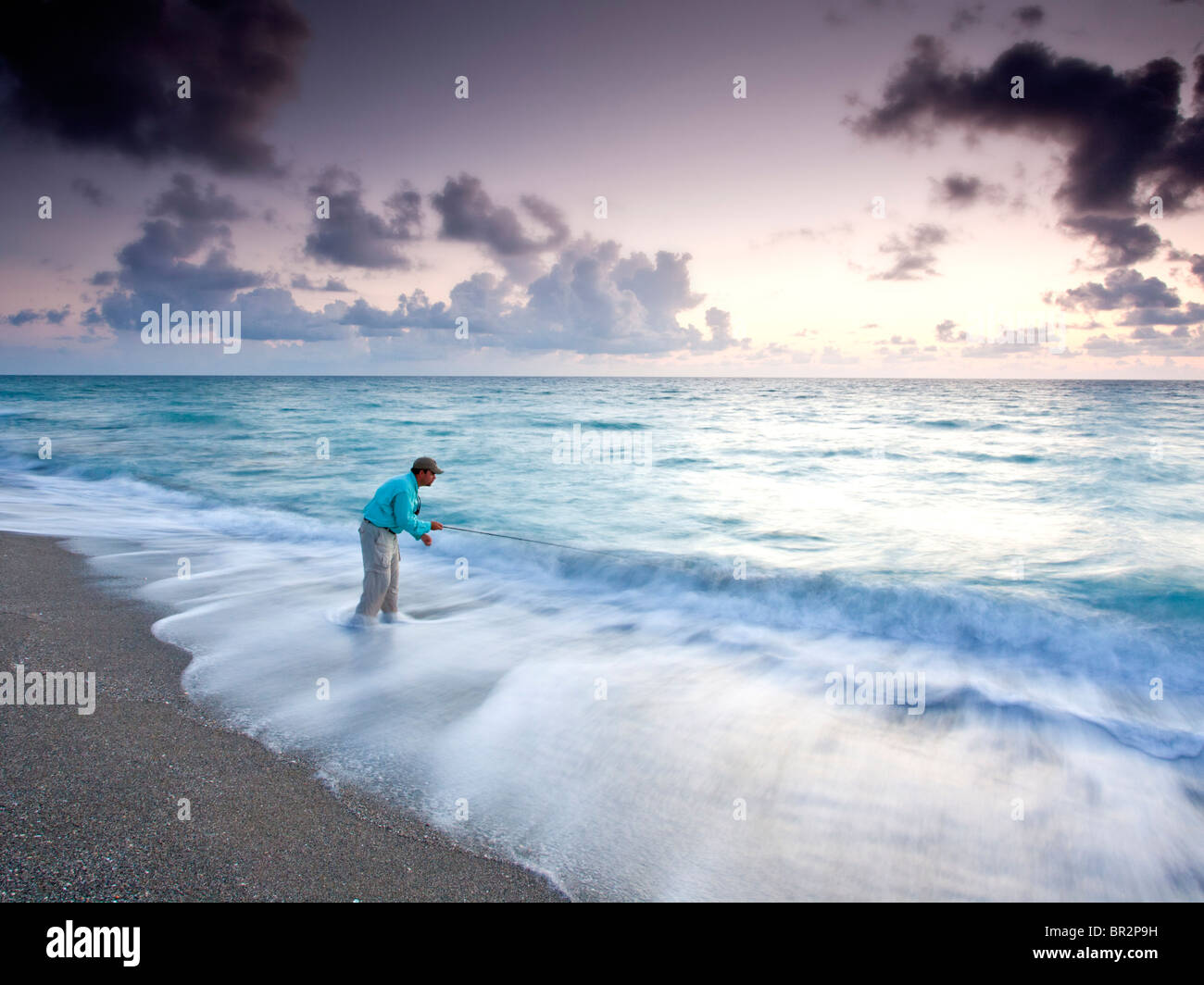 Man fly fishing in the surf of ocean at the beach Stock Photo - Alamy