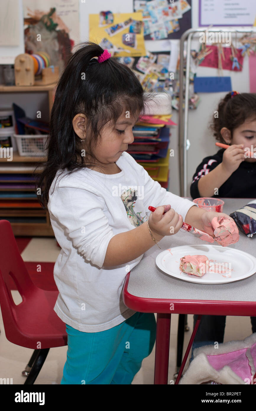 4 year old preschool girl working on an art project in the classroom ...