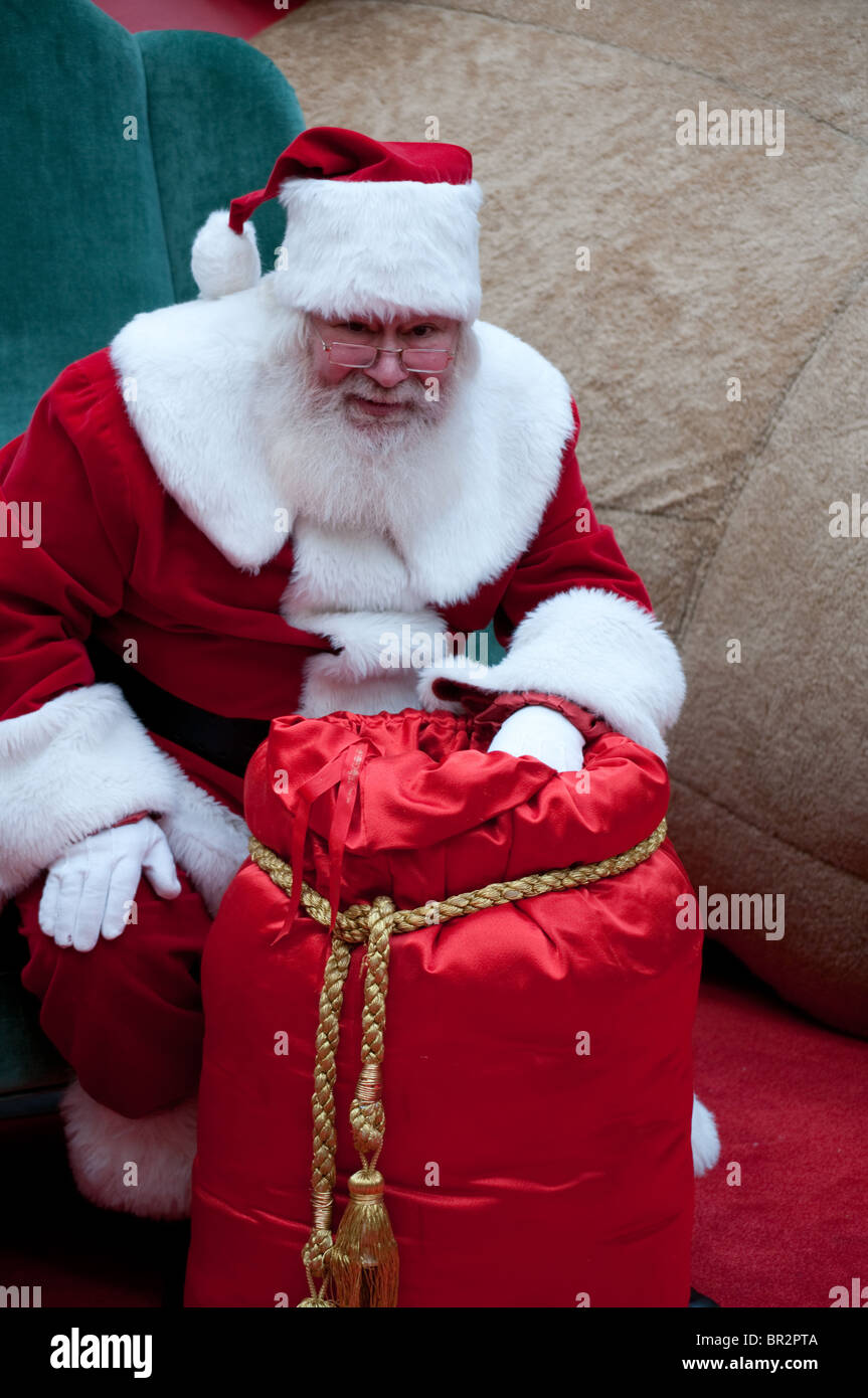 Santa looking up from his big red toy gift bag Stock Photo - Alamy