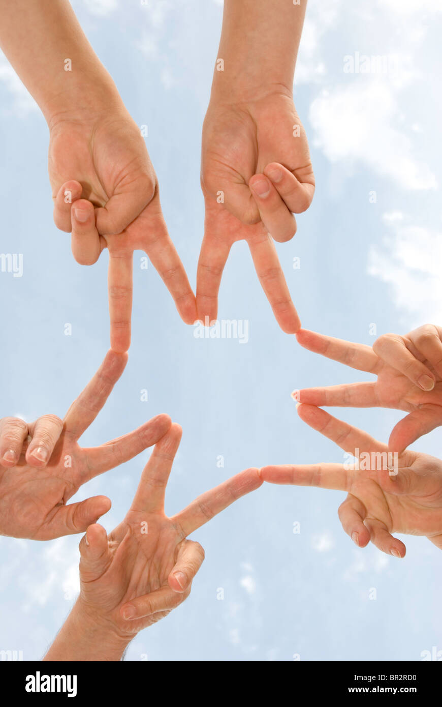 fingers of team on sky background(special toned , focus on hands ...