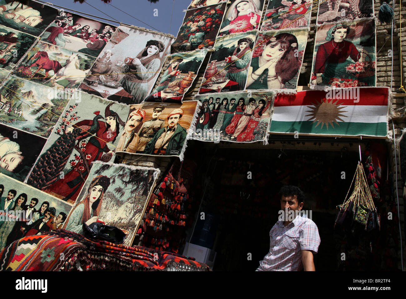 A man selling carpets with images of Kurdish motif in the city of Erbil ...