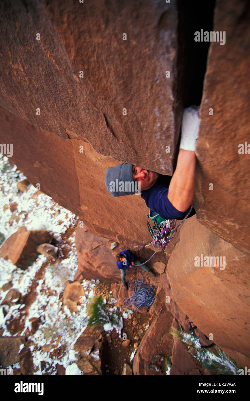 Man jamming his fist in a crack while crack climbing (High Angle ...