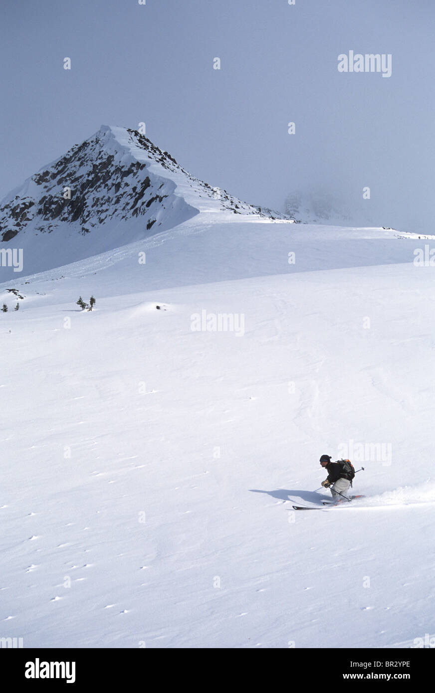 Male skier making turns beneath peak Stock Photo - Alamy