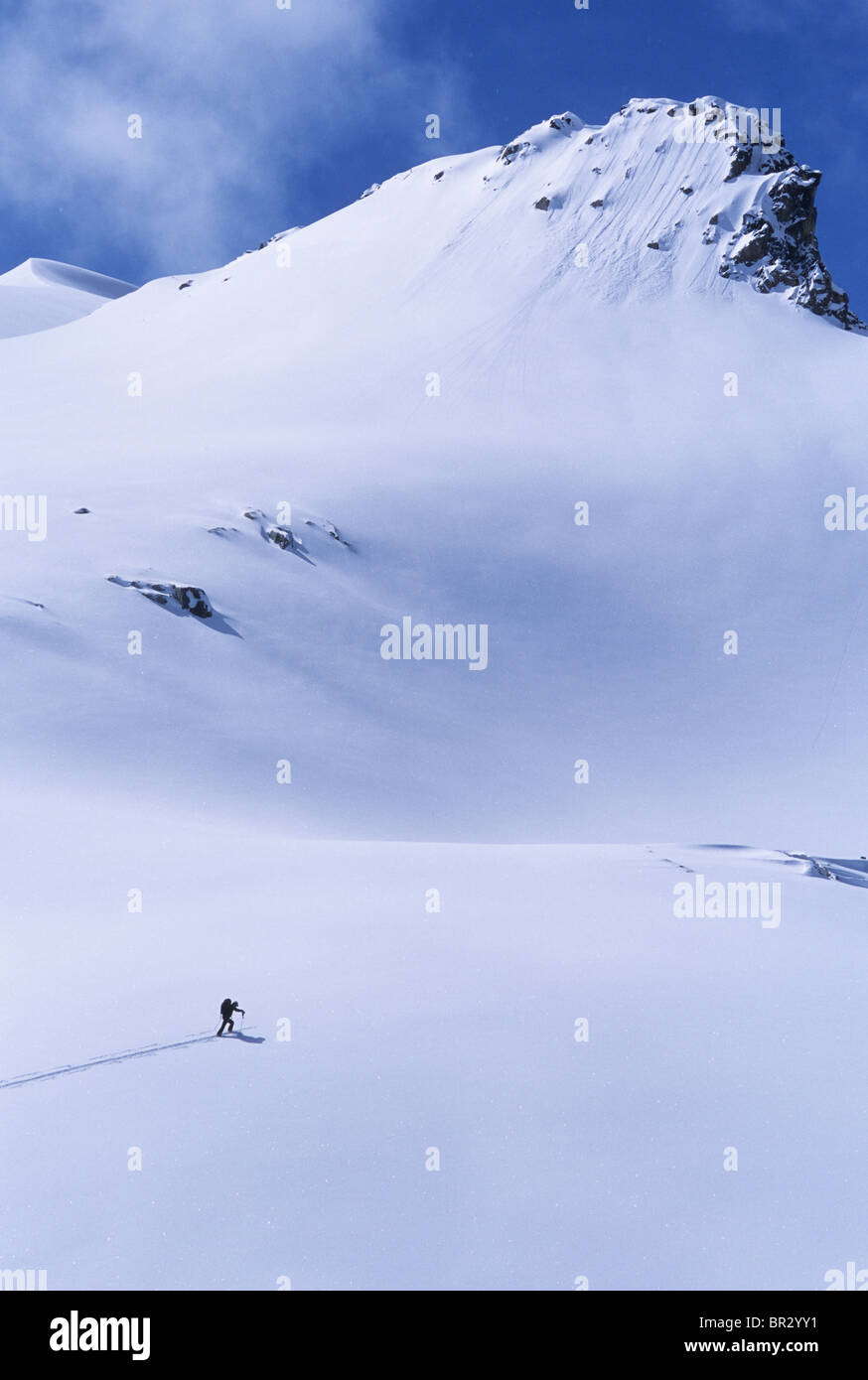 Single backcountry skier below large peak Stock Photo - Alamy