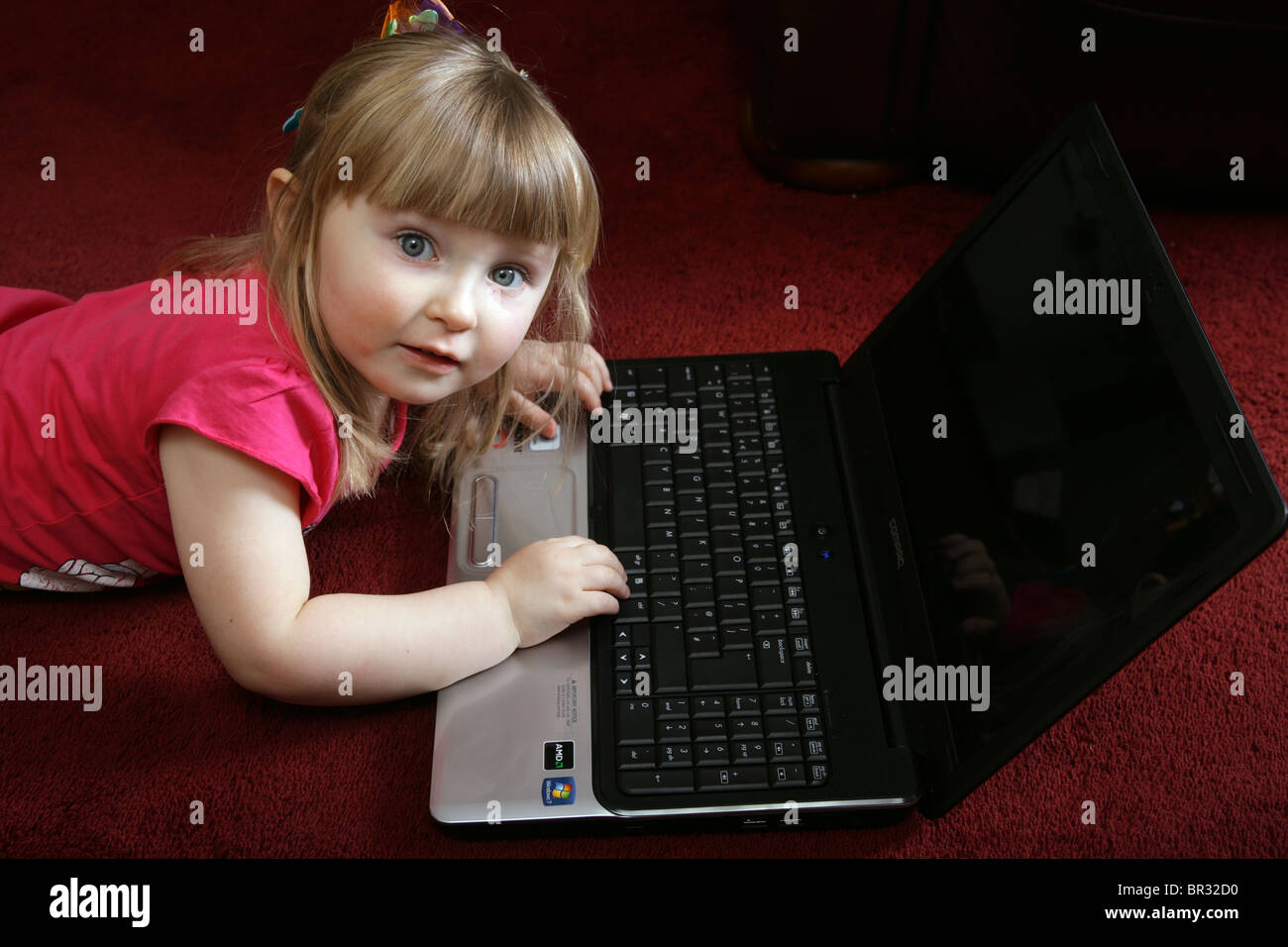 Two year child using a laptop on the floor Stock Photo - Alamy