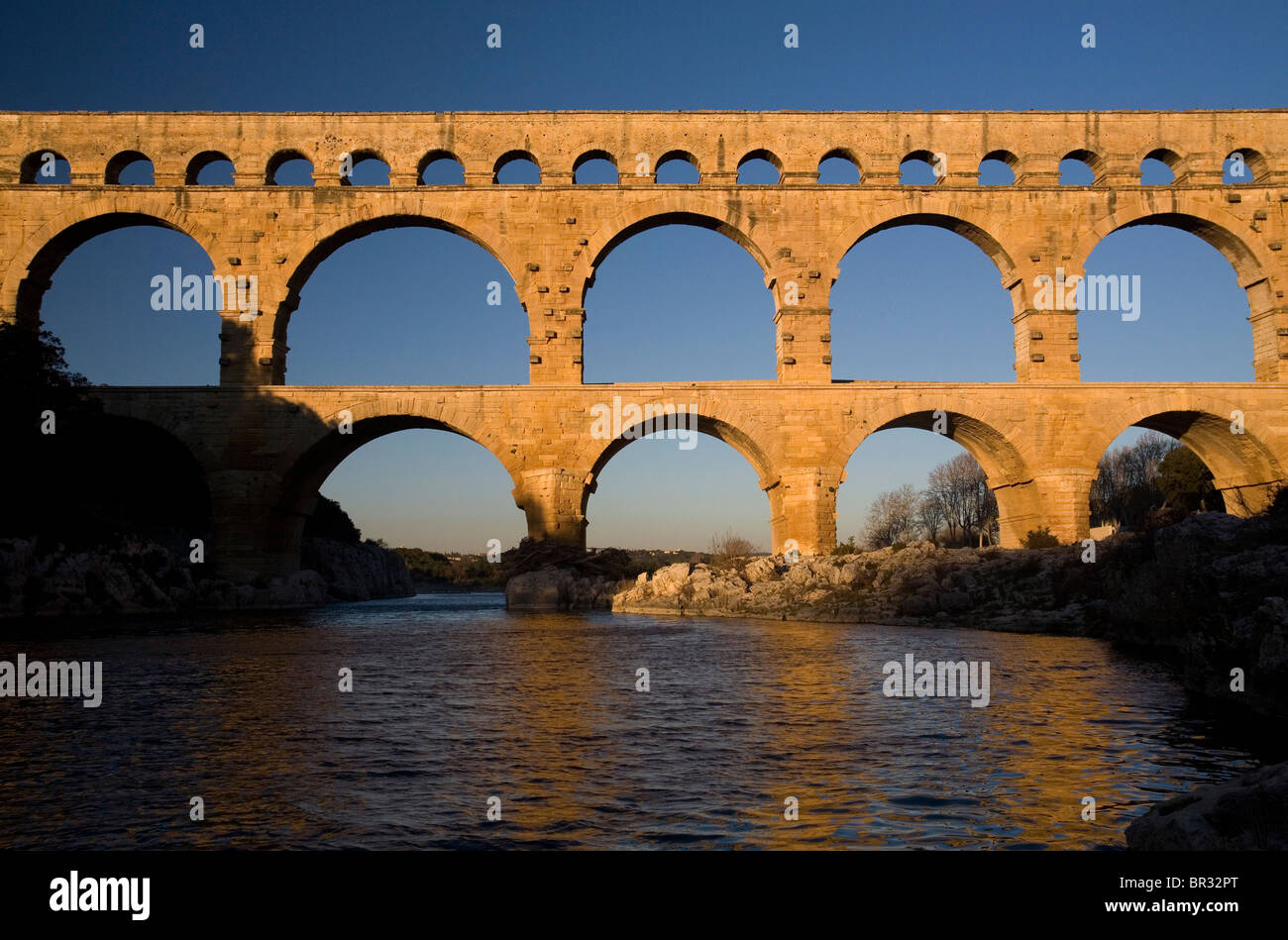 River flows under ancient Roman Aquaduct lit up by the sunset Stock ...