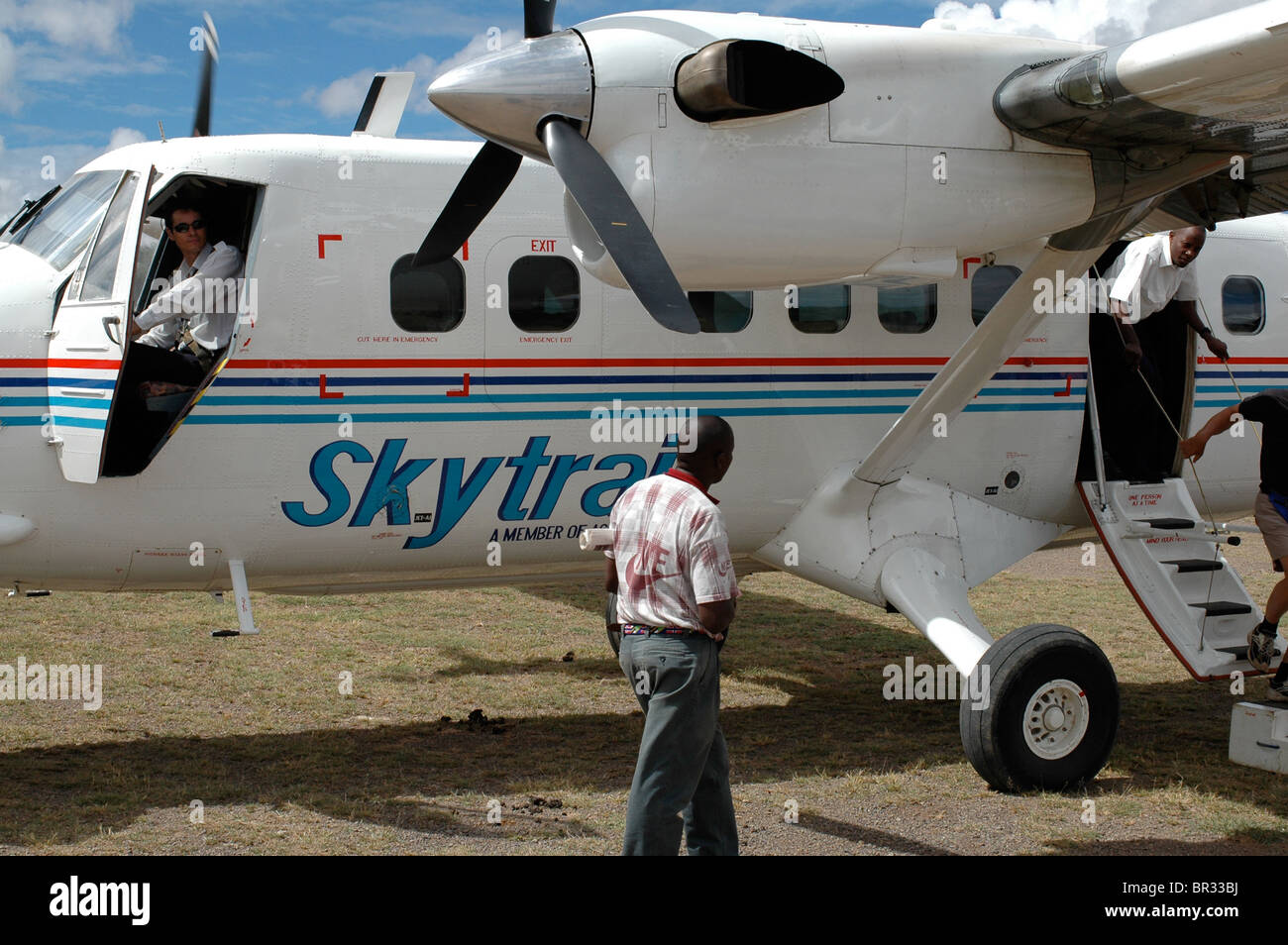 light aircraft in africa for safari with pilot looking out of open door ...