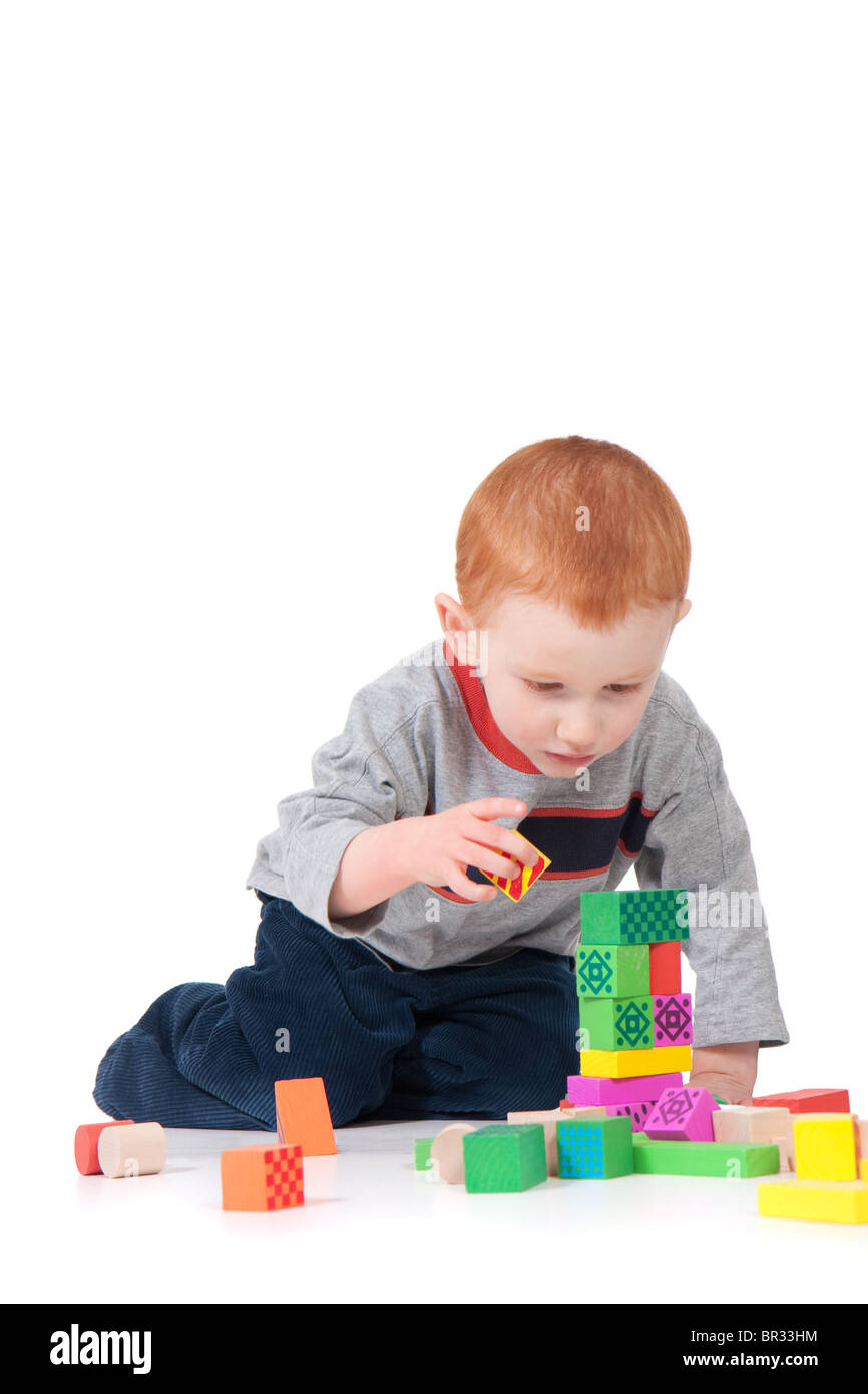 Boy building colorful block tower. Isolated on white with shadows Stock ...
