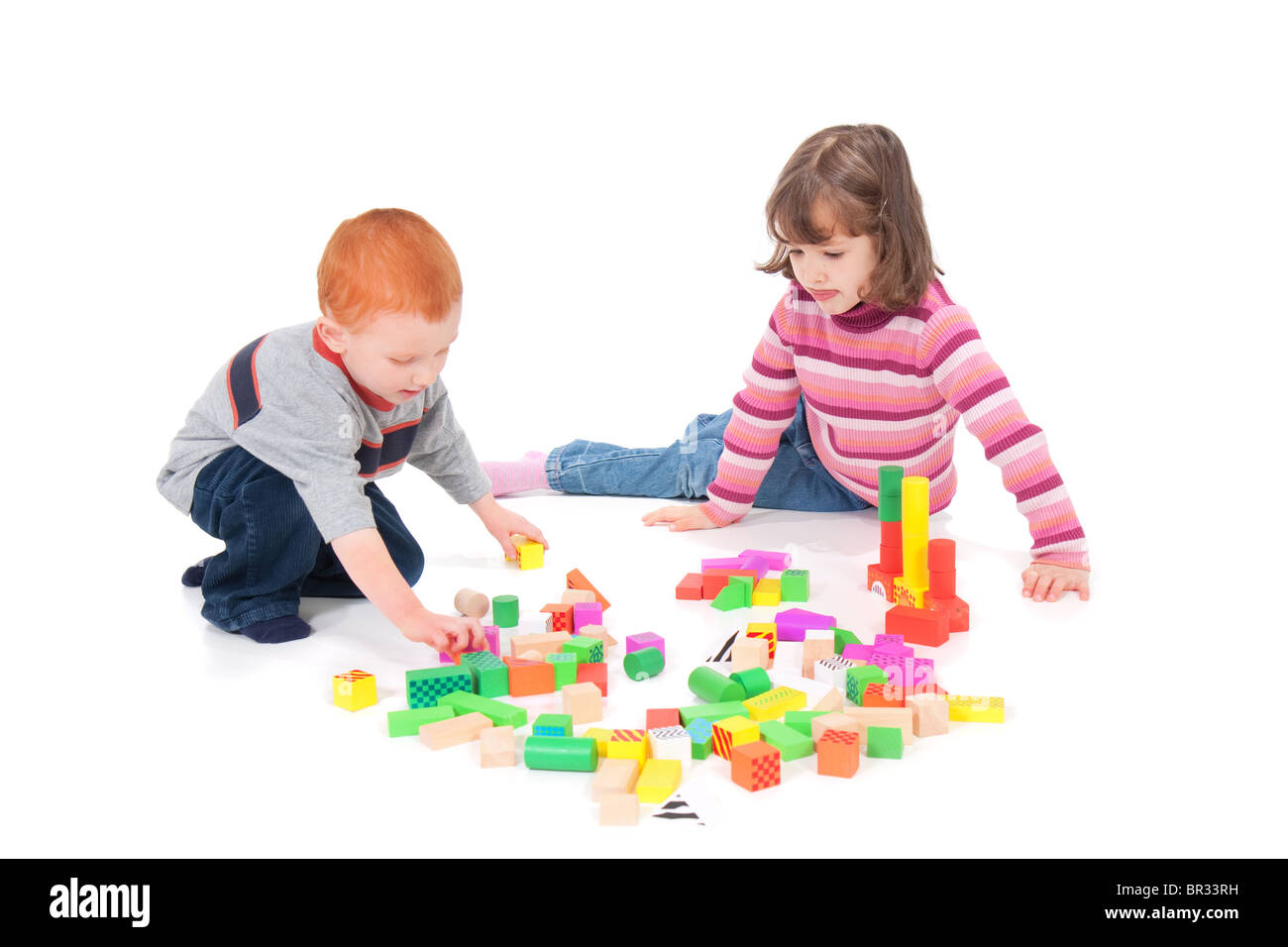 Two kids playing with colorful blocks. Isolated on white with shadows ...
