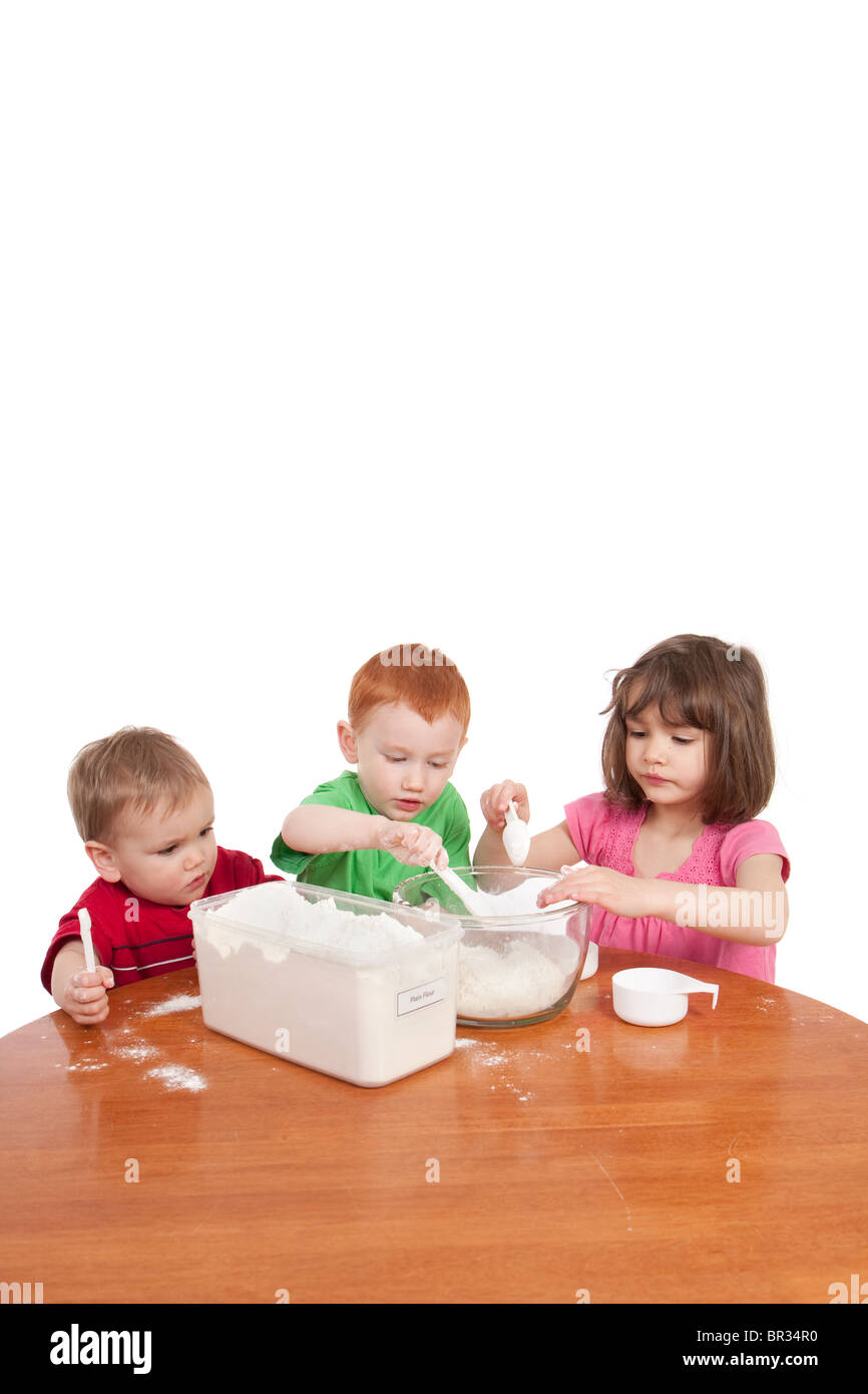Three kids measuring flour and mixing in kitchen bowl. Isolated on ...