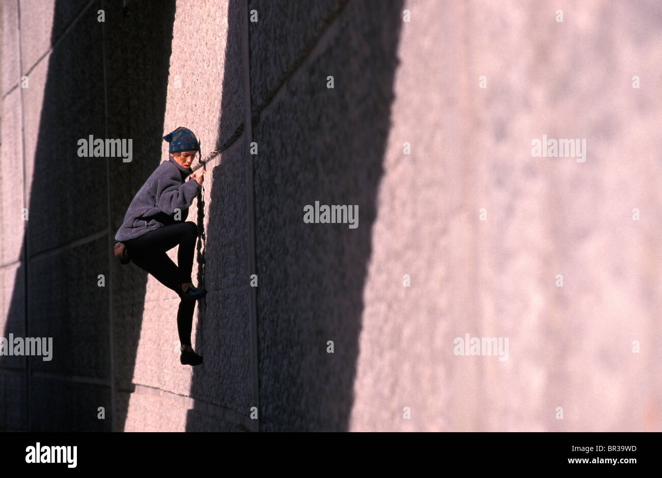 Attractive female climber buildering on the side of a building Stock ...