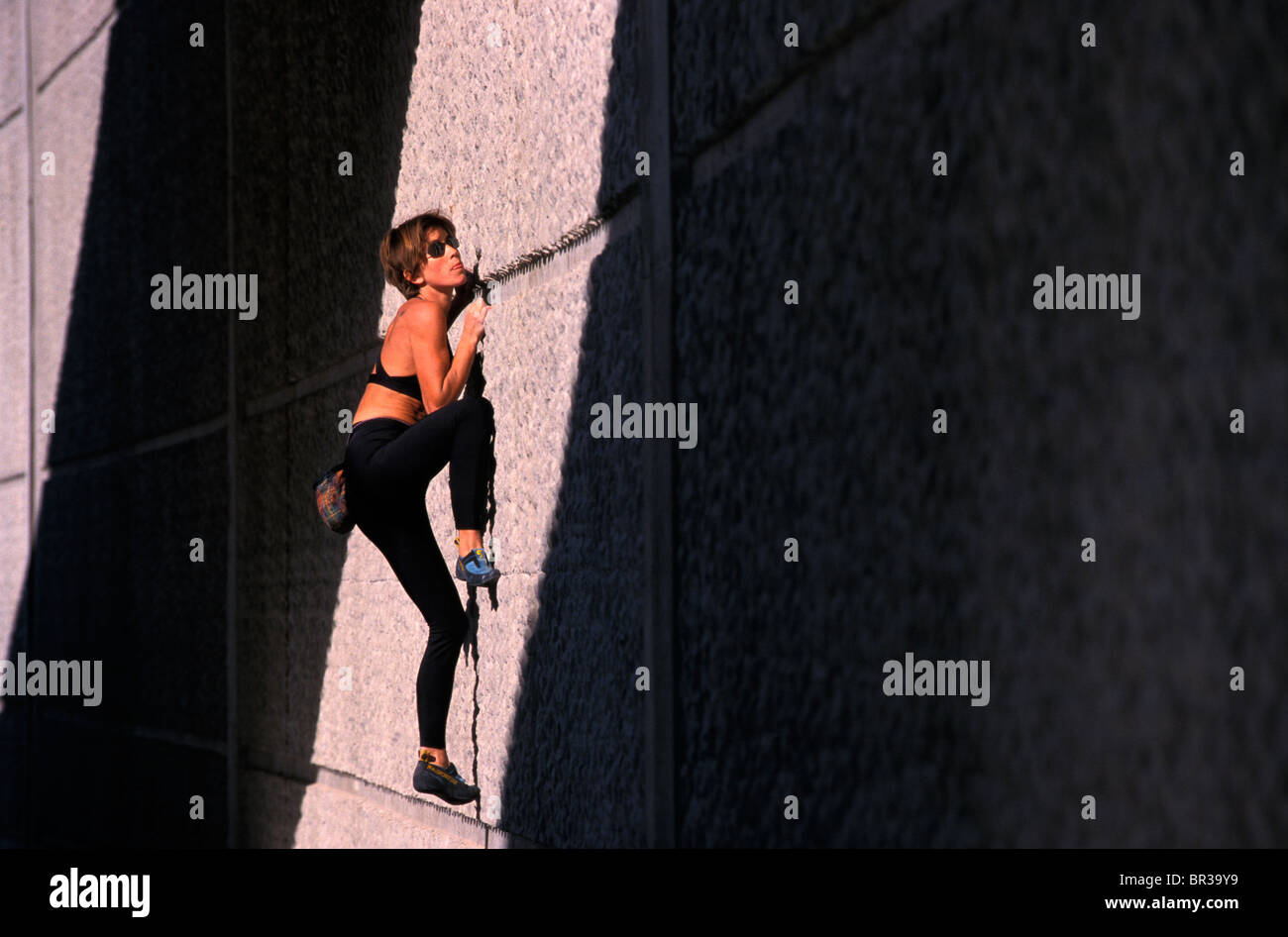 Attractive female climber buildering on the side of a building Stock ...