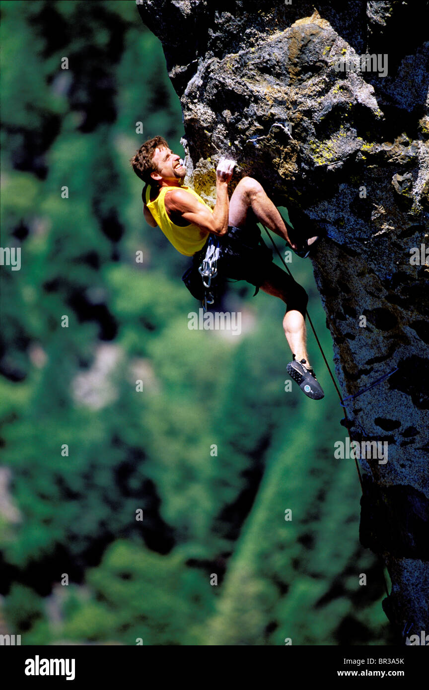 Male climber on an overhang high above a valley Stock Photo - Alamy