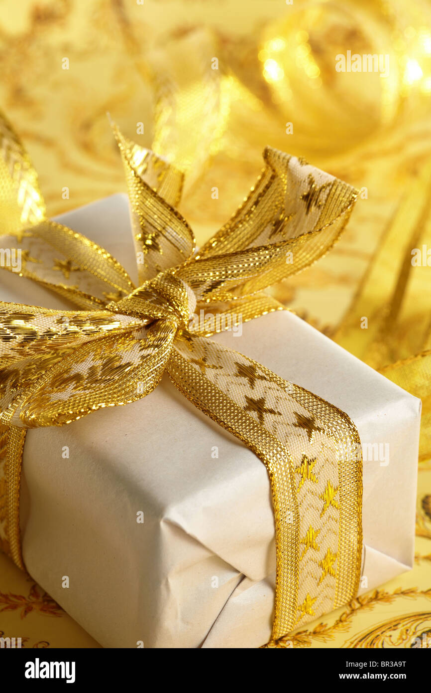 Beautiful gift box on the gold background Stock Photo - Alamy
