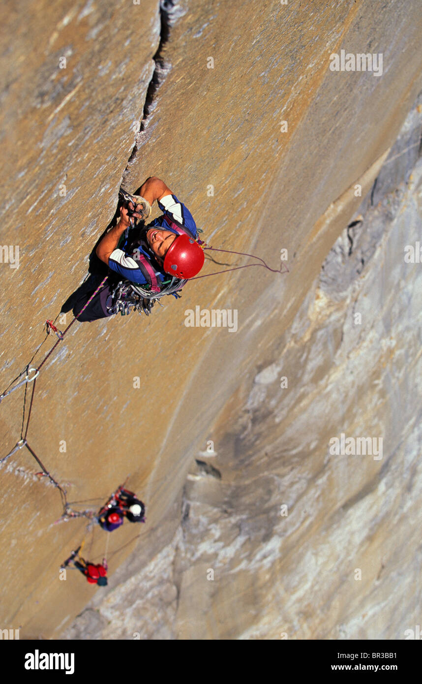 Man climbing a big wall and placing protection (high angle perspective ...