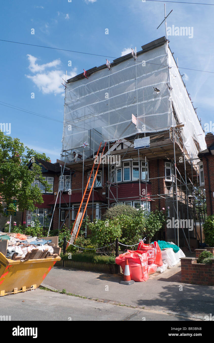 A skip sits outside a house in the process of having a loft conversion ...