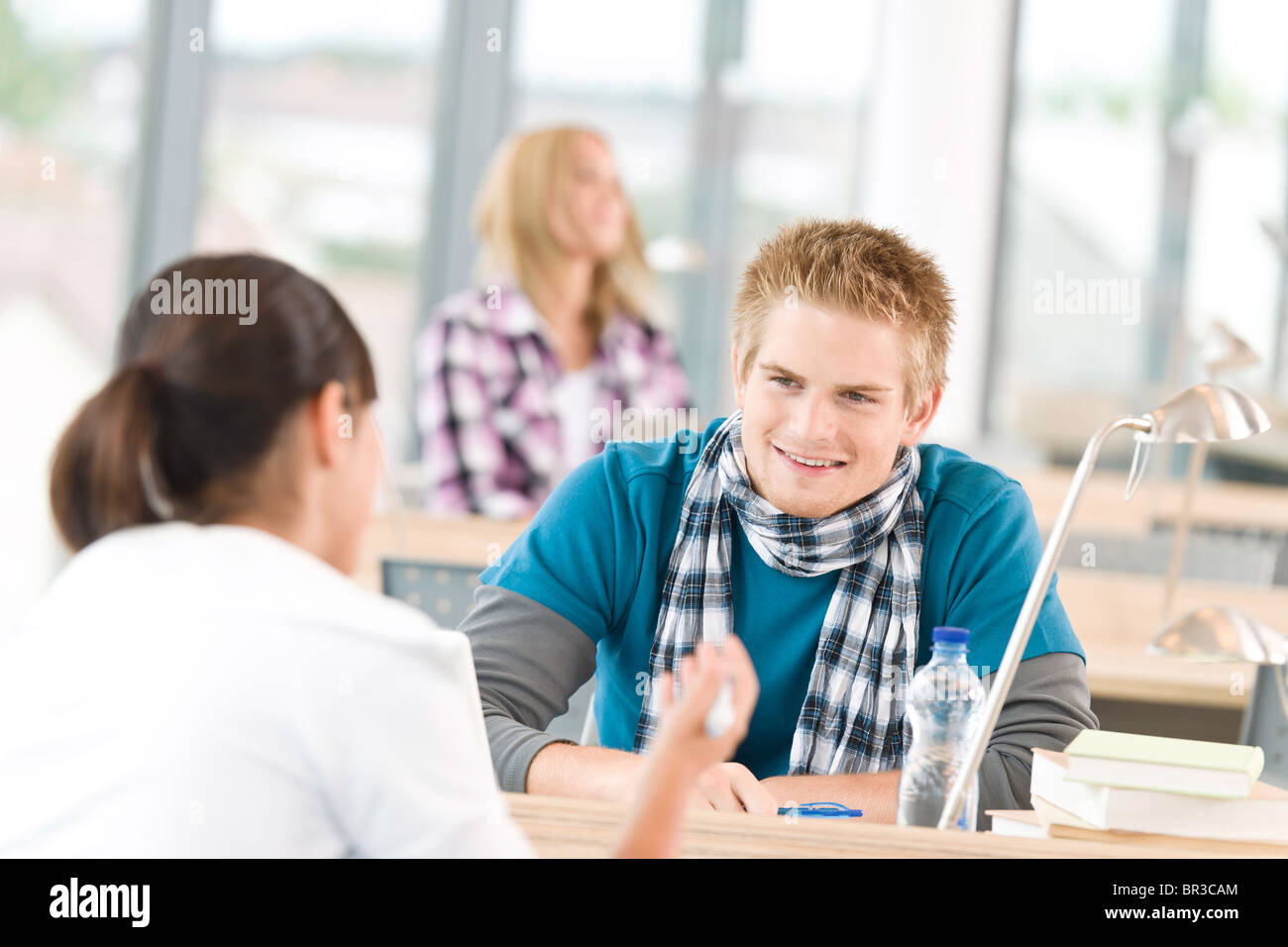 Three high school students in classroom studying with books Stock Photo ...