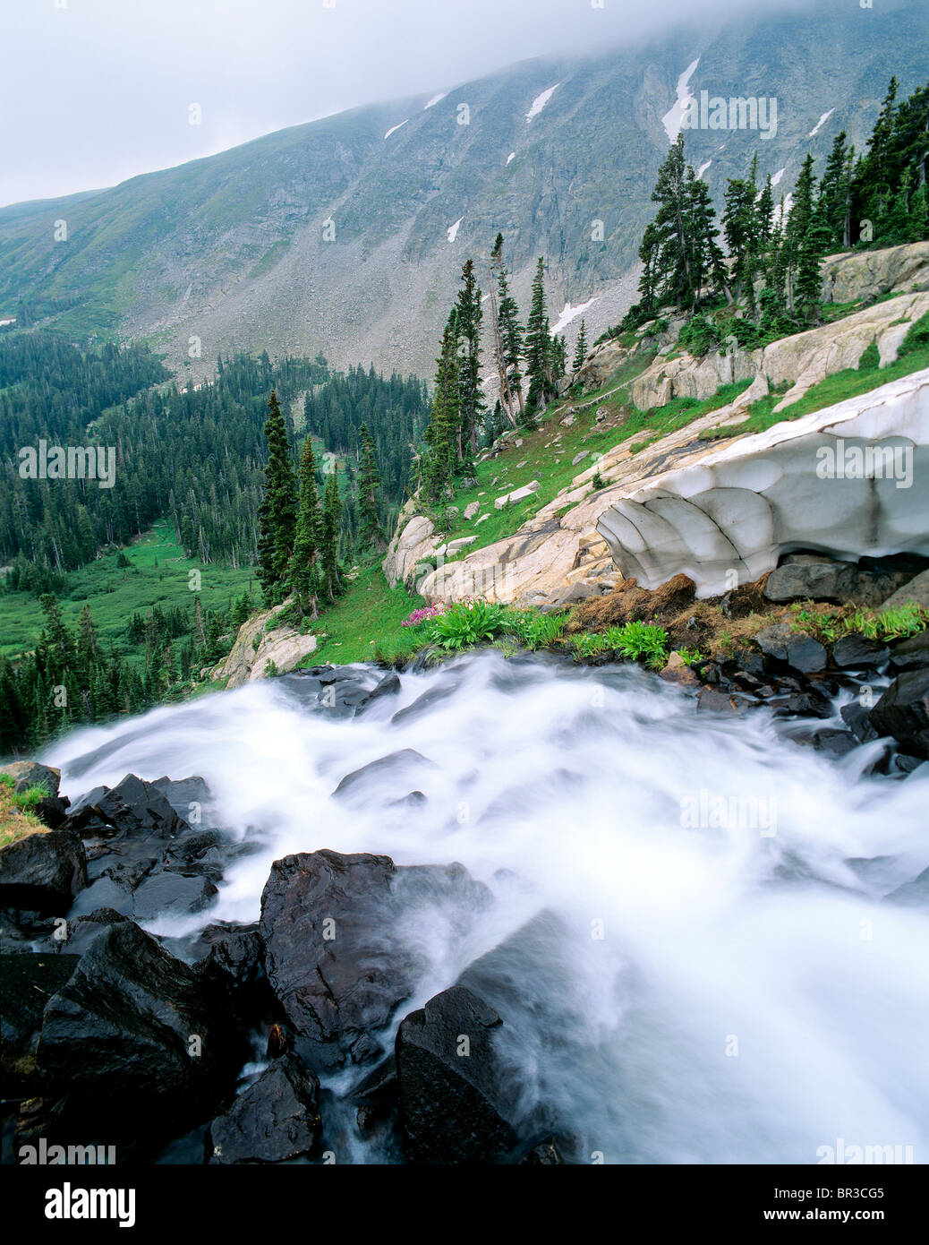 A waterfall flows out of Lake Isabelle in early Spring in the Indian ...