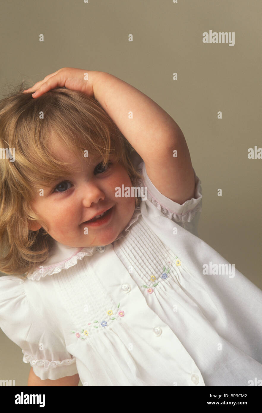cute little toddler touching her head Stock Photo - Alamy