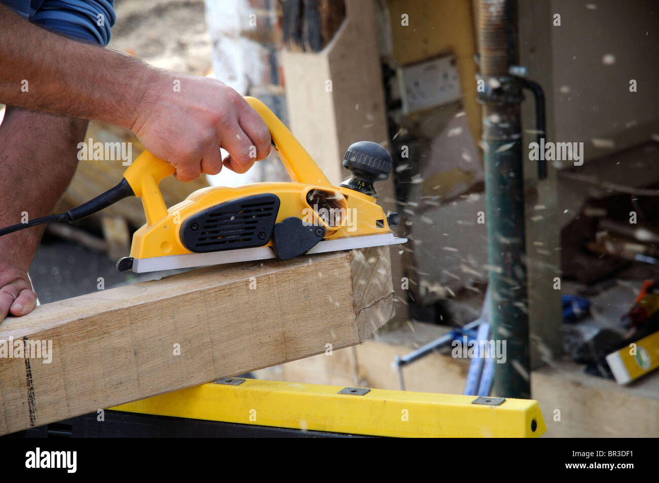 Carpenter using an electric plane on a piece of oak Stock Photo - Alamy