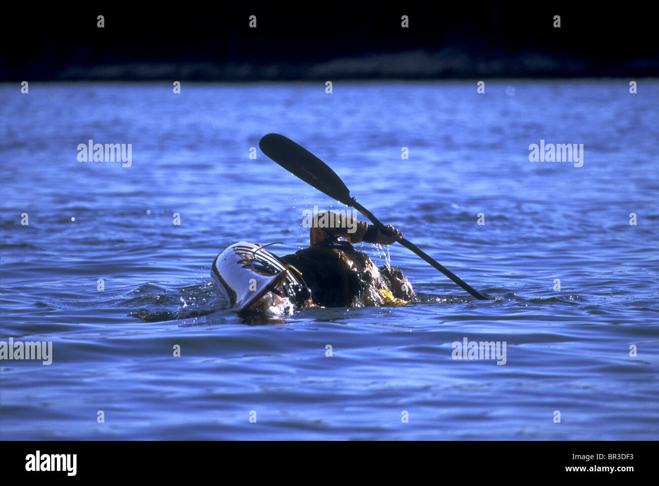 A man performs an eskimo roll in his sea kayak near Thief Island on ...