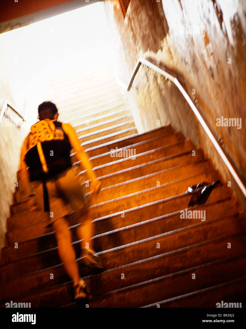 Rear view of a person walking up stairs Stock Photo - Alamy