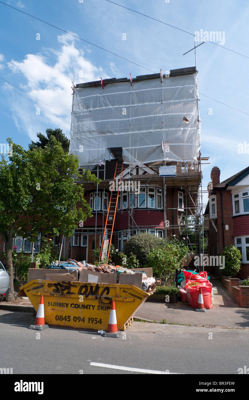A skip sits outside a house in the process of having a loft conversion ...