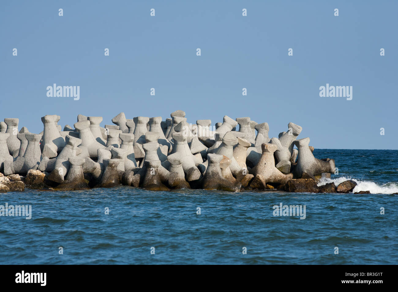 Landscape with breakwater dam rocks and blue sky Stock Photo - Alamy