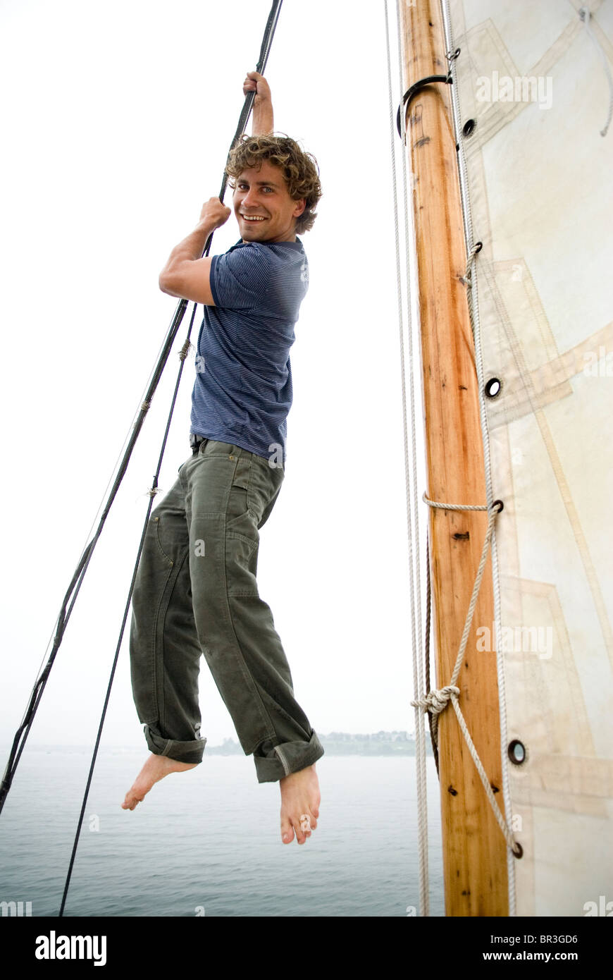 Man climbing rigging onboard sailboat, Casco Bay, Maine, New England ...
