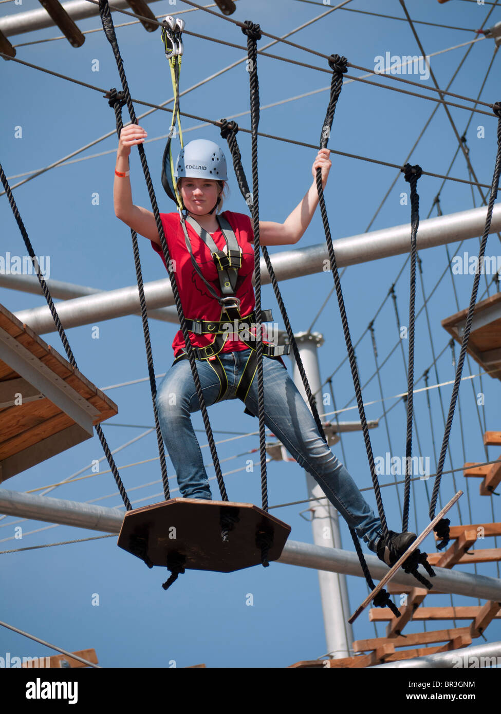 Woman climbing on modern new outdoor adventure playground featuring ... Woman climbing on modern new outdoor adventure playground featuring ...