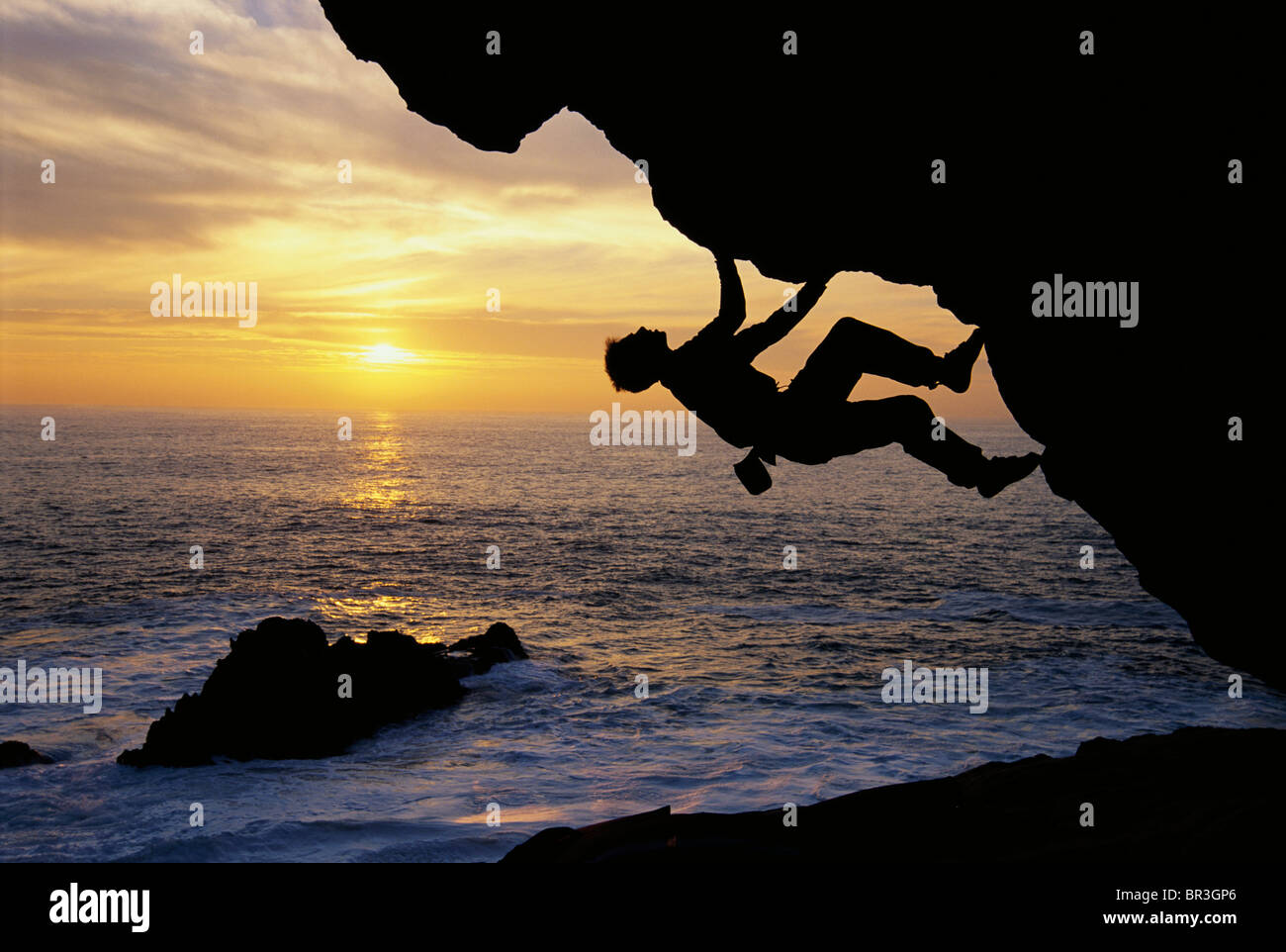 Climber silhouetted over the ocean at sunset Stock Photo - Alamy