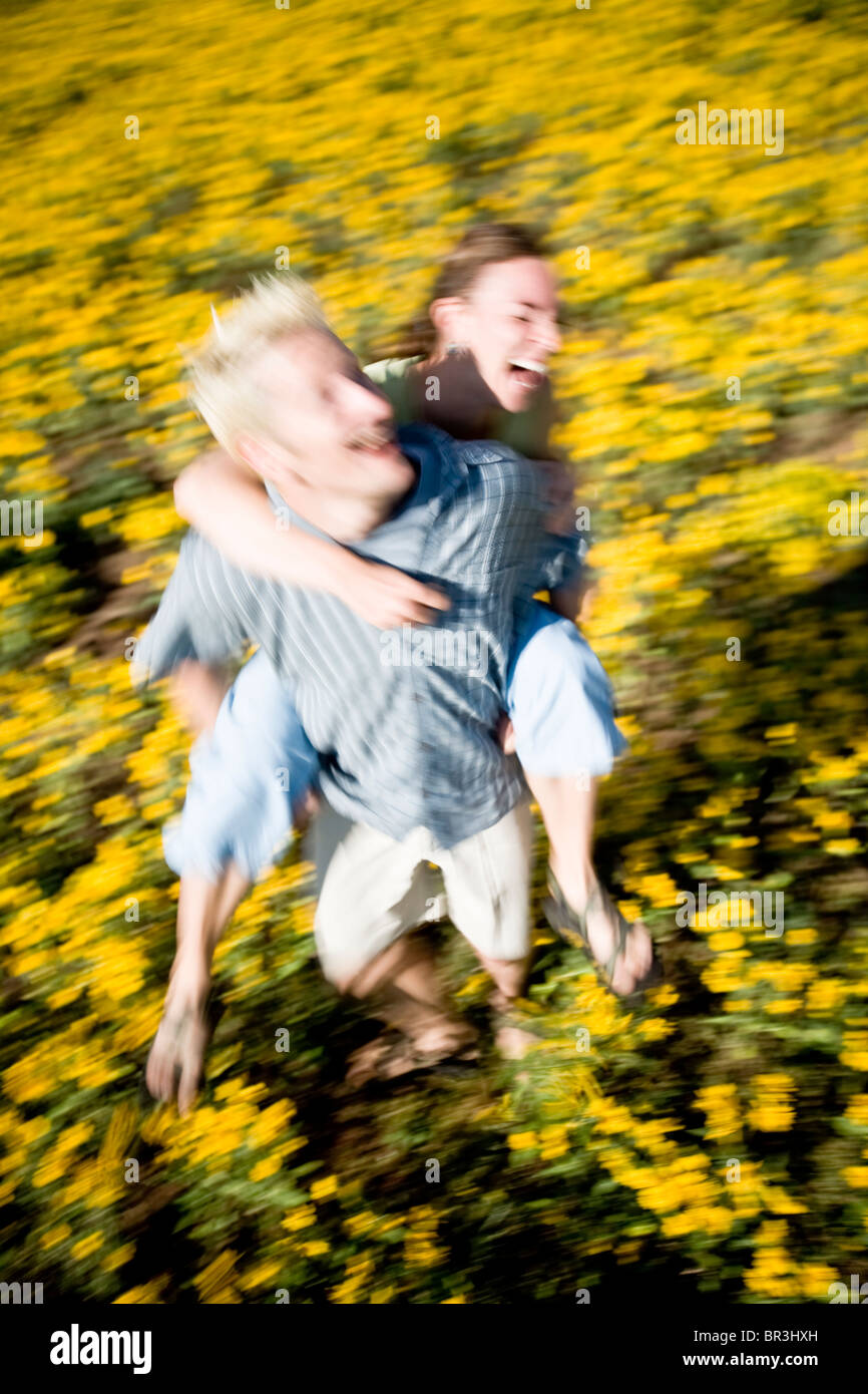 Two people spinning in circles while giving a piggy back ride in a ...