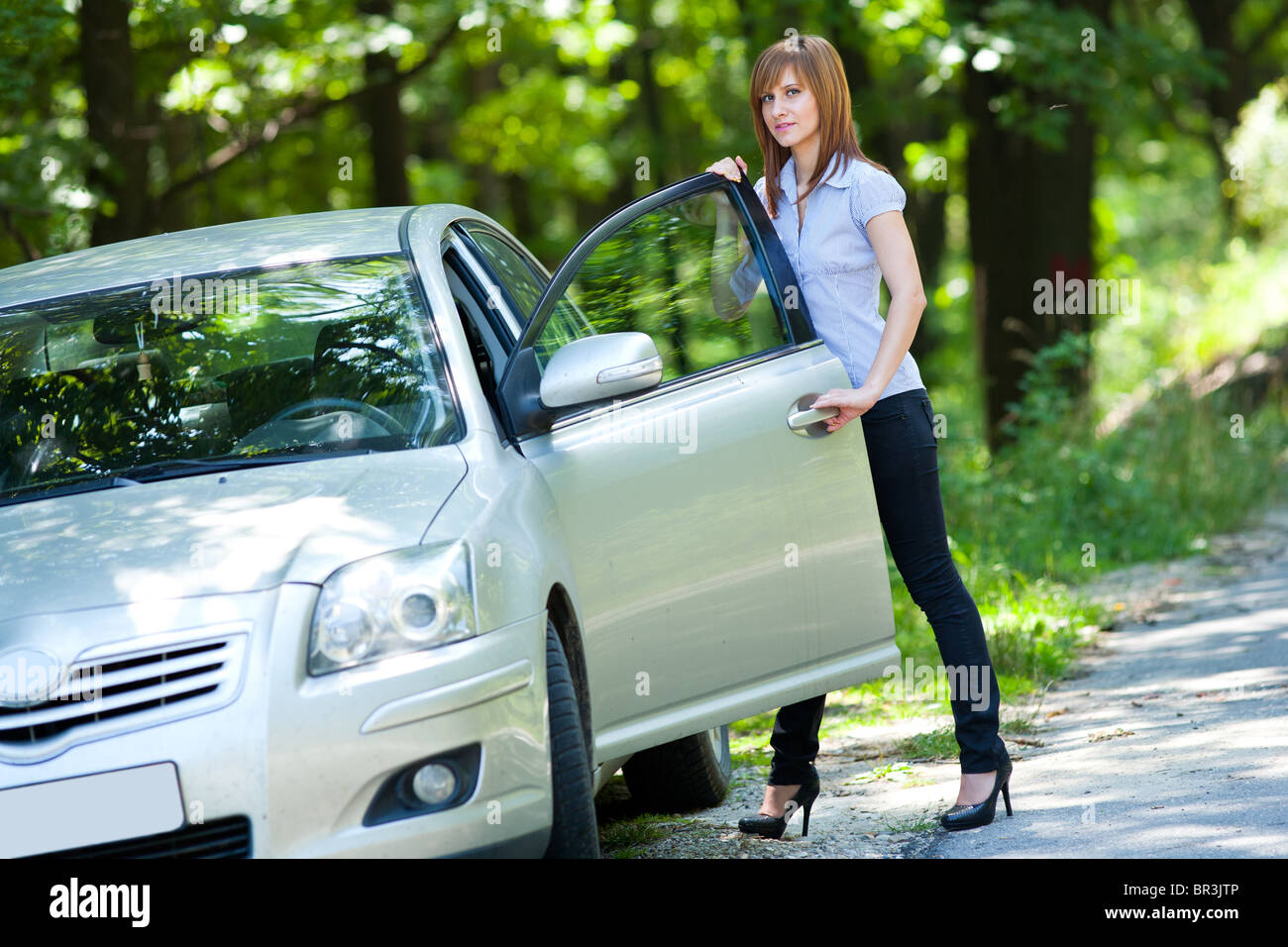 Business woman standing near by her car in a forest Stock Photo - Alamy
