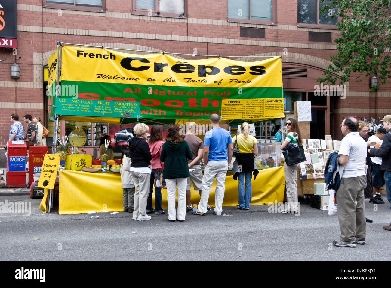 a diverse crowd in front of the colorful crepe stand at New York's ...