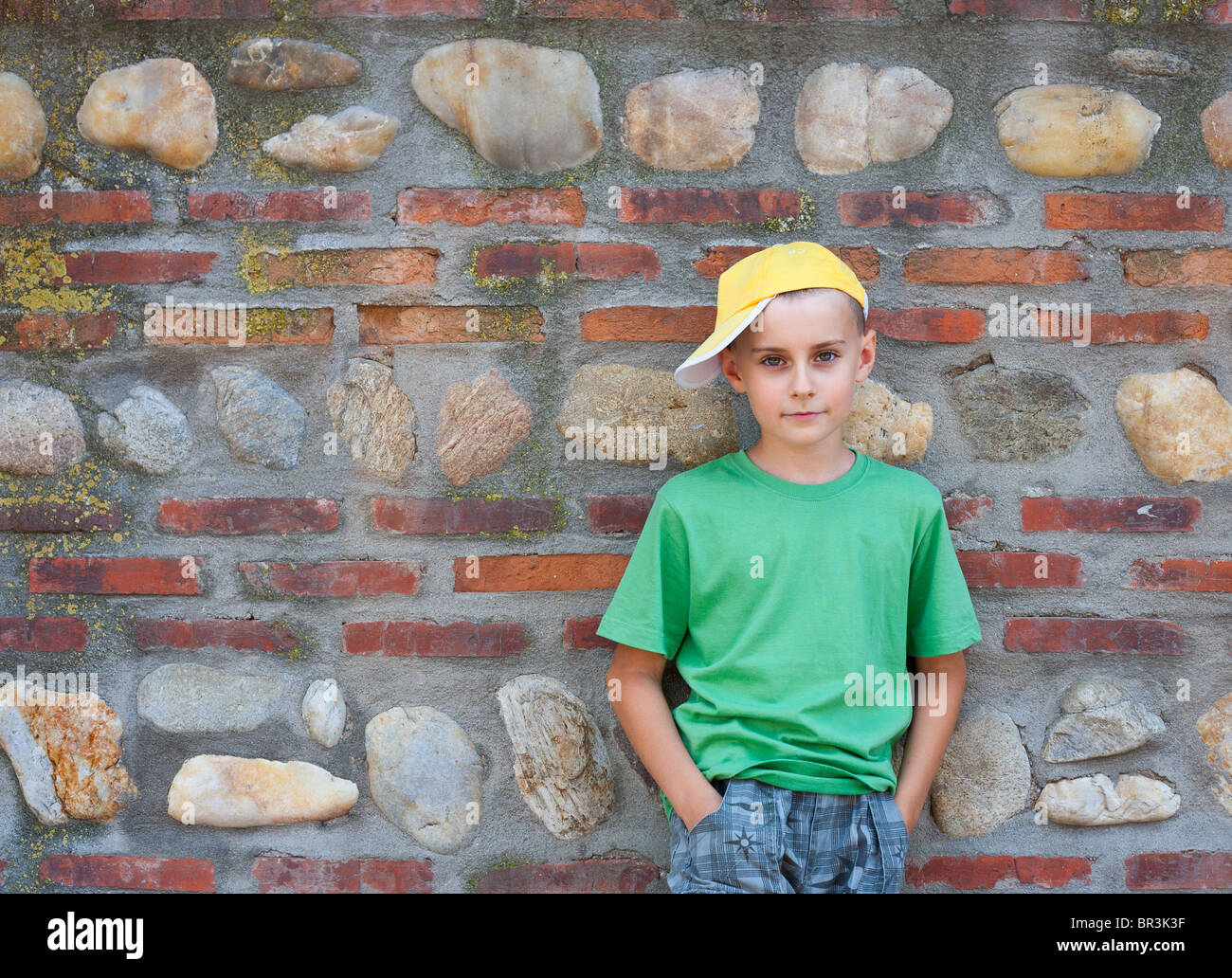 Portrait of a beautiful child leaning on an old brick wall Stock Photo ...